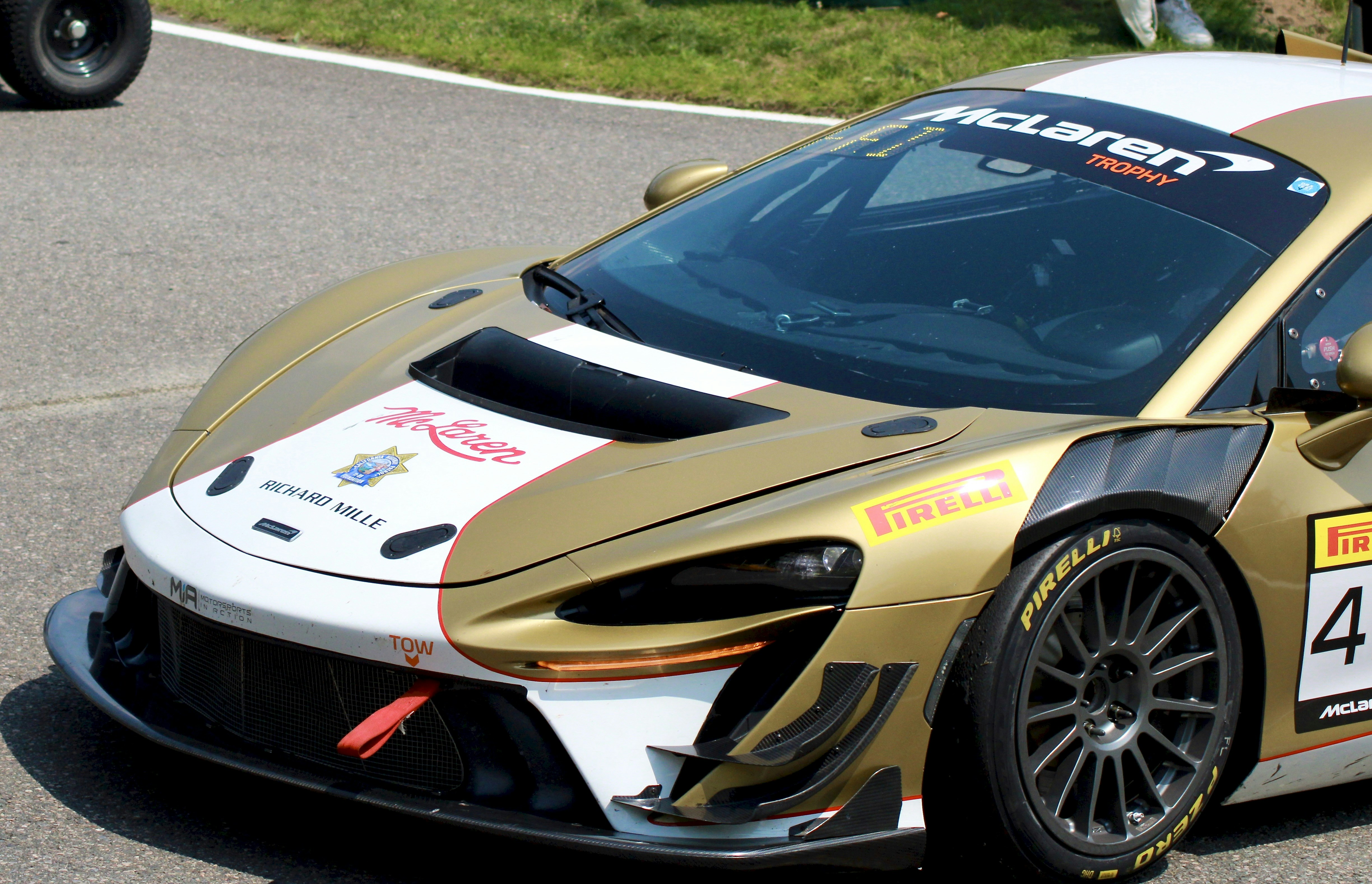 Gold and White McLaren Race Car Entering the Curve