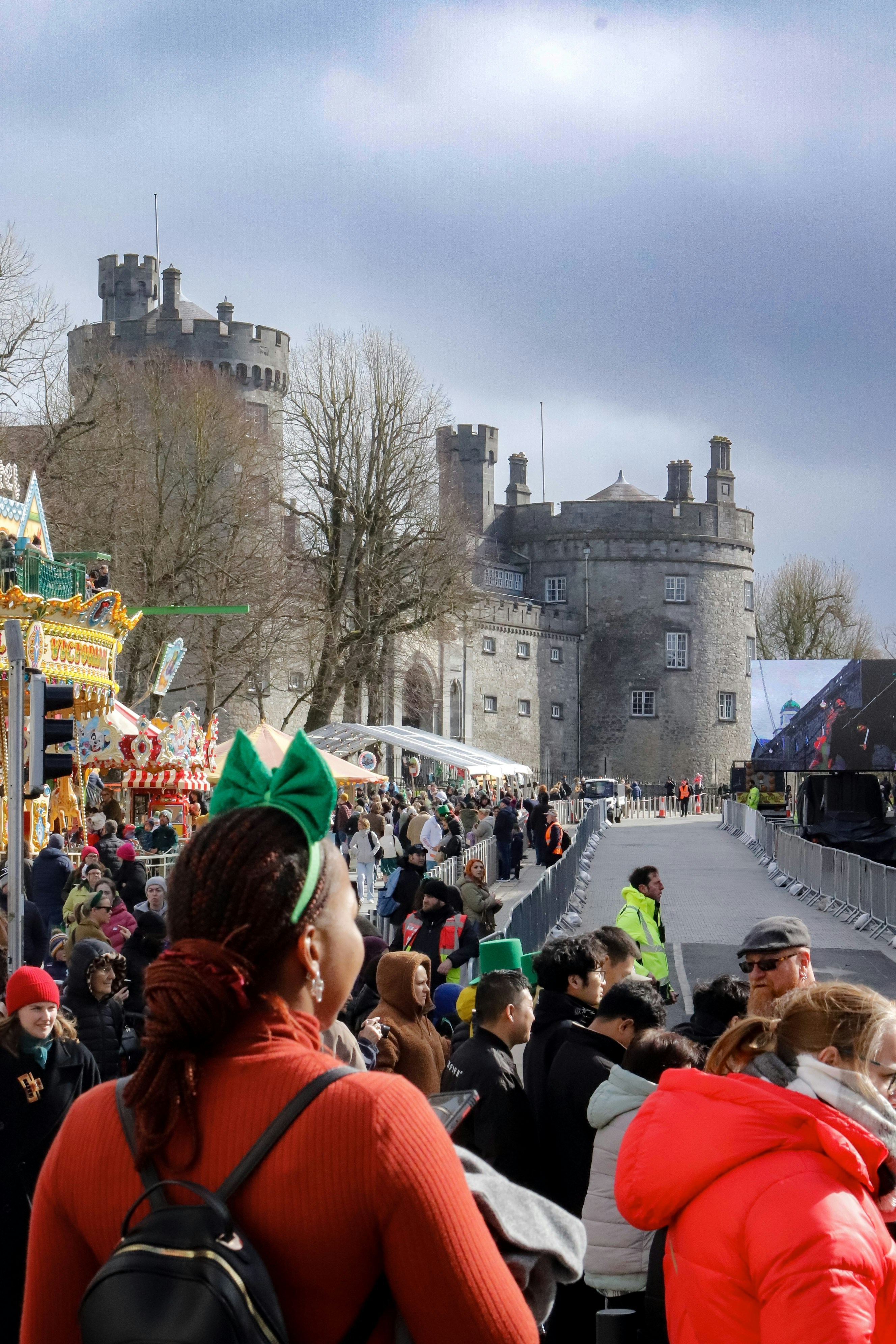 Castle Fairgrounds: Crowds at the Gate Beneath Thunderous Clouds