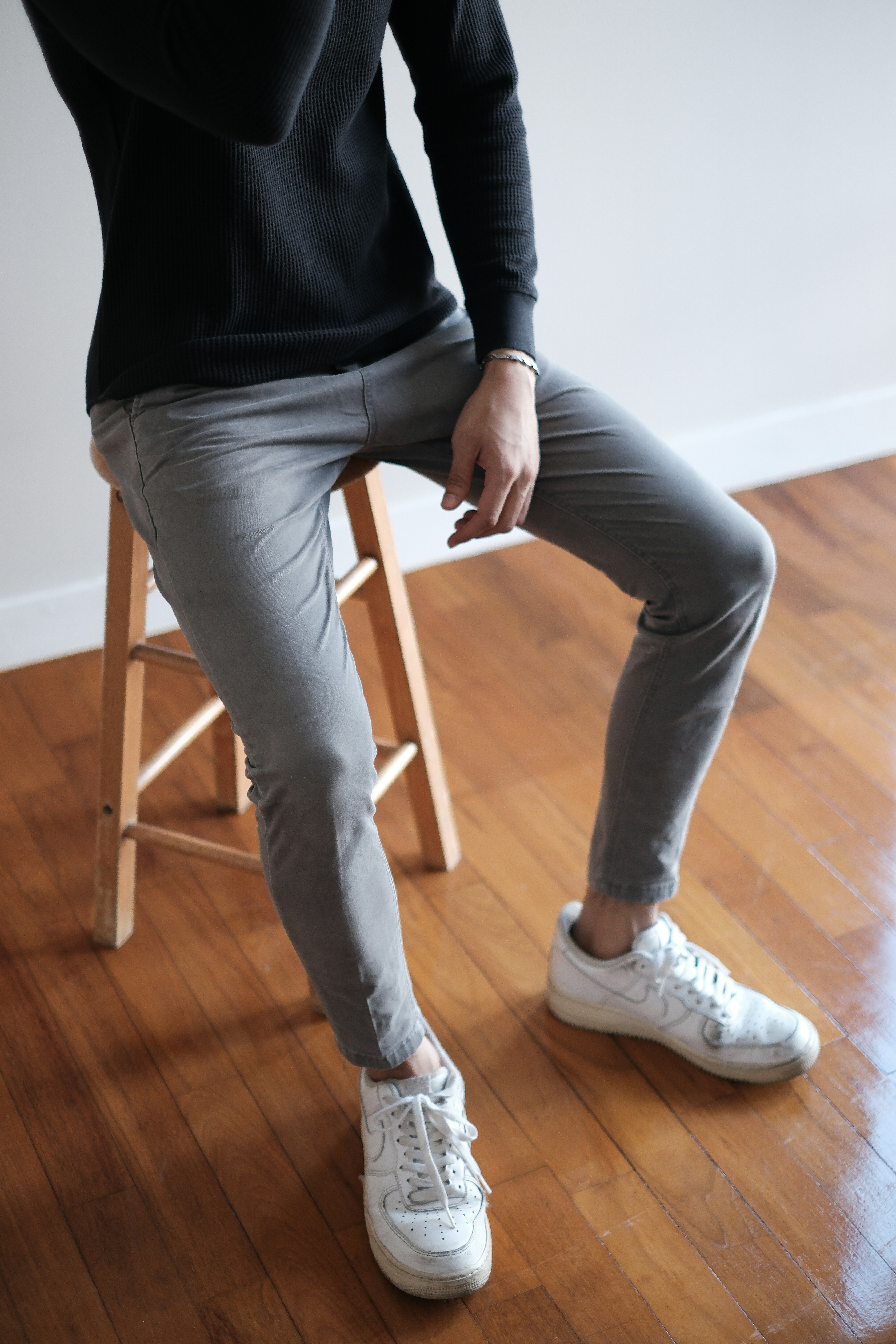 Casual Confidence: A Languid Pose on a Stool in Soft Light