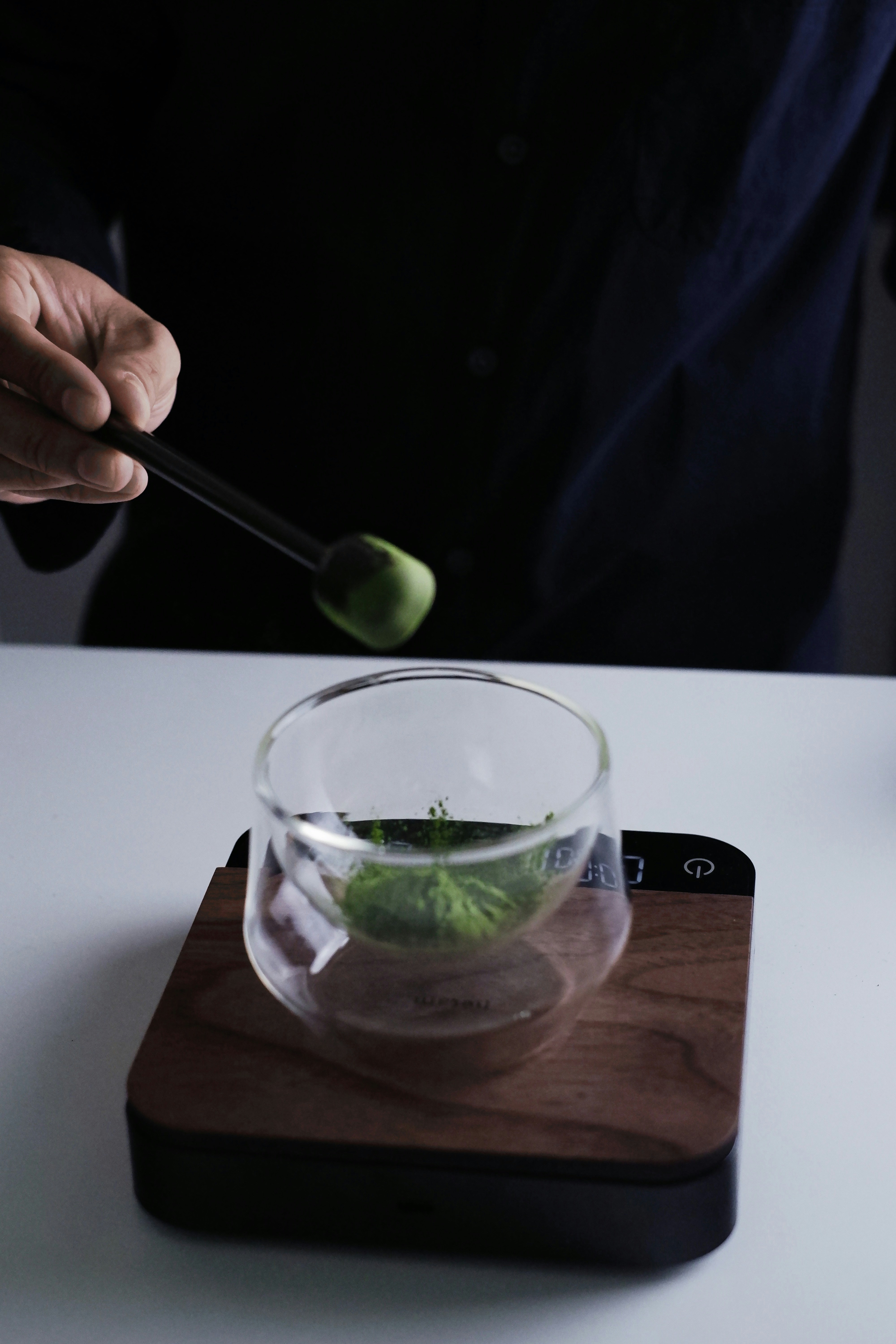Gently Stirred Echoes: A Green Domed Drop Hovers Over Tea