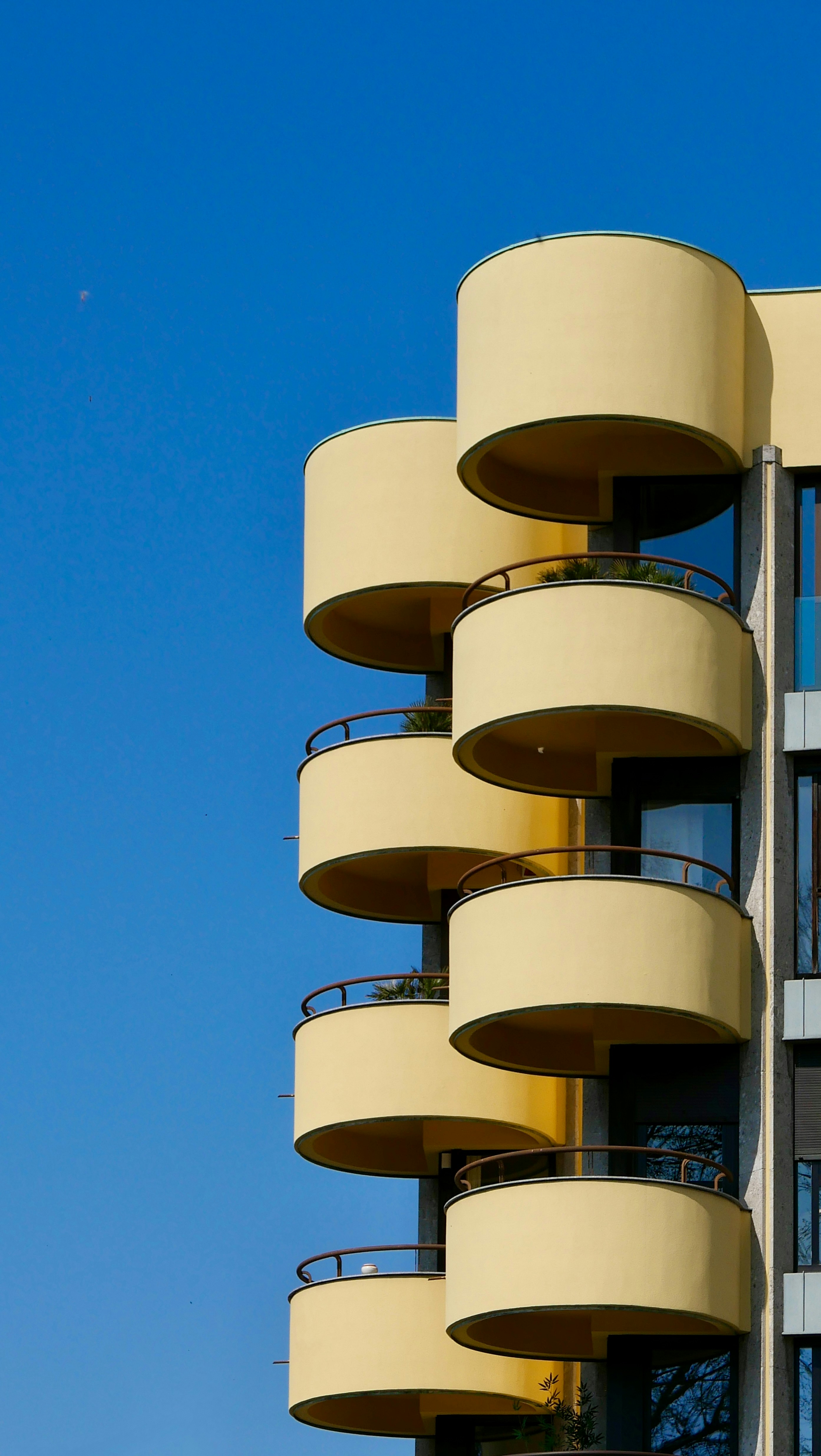Curved yellow balconies ascend against a sapphire sky