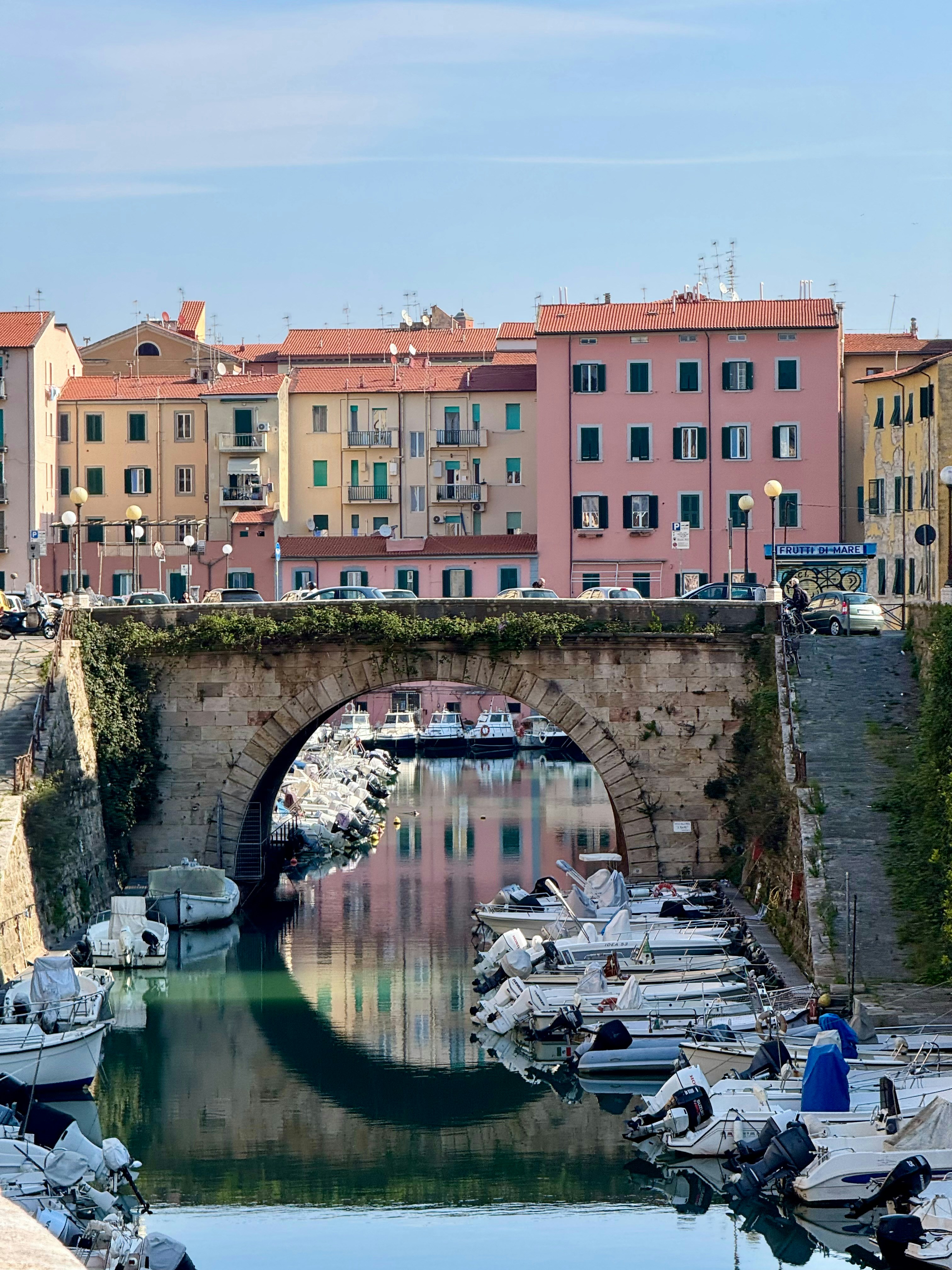 Pastel harbor arches: sunlit town over a mirrored canal