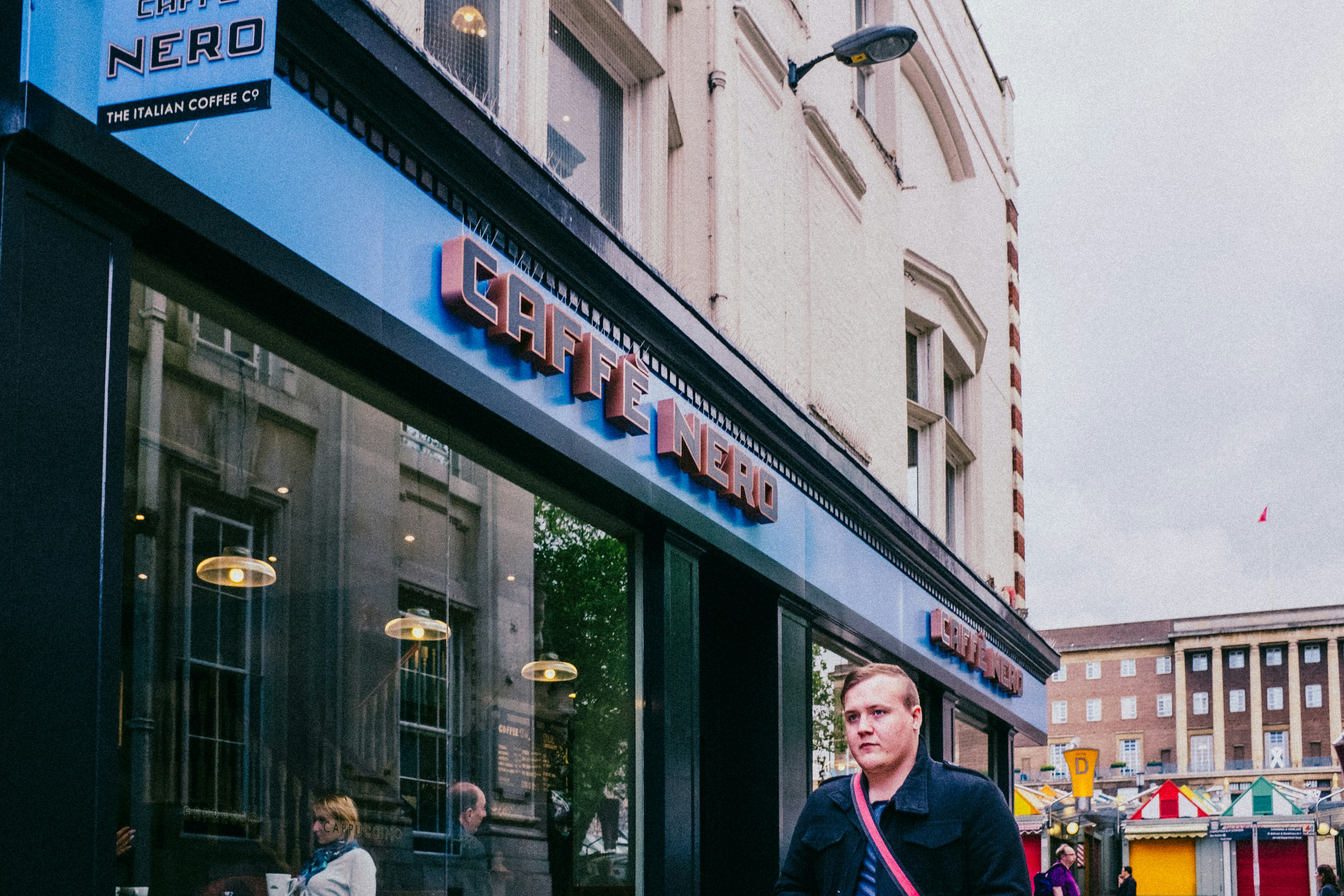 Cafe Nero Corner: A Pedestrian Passes the Street-Side Scene