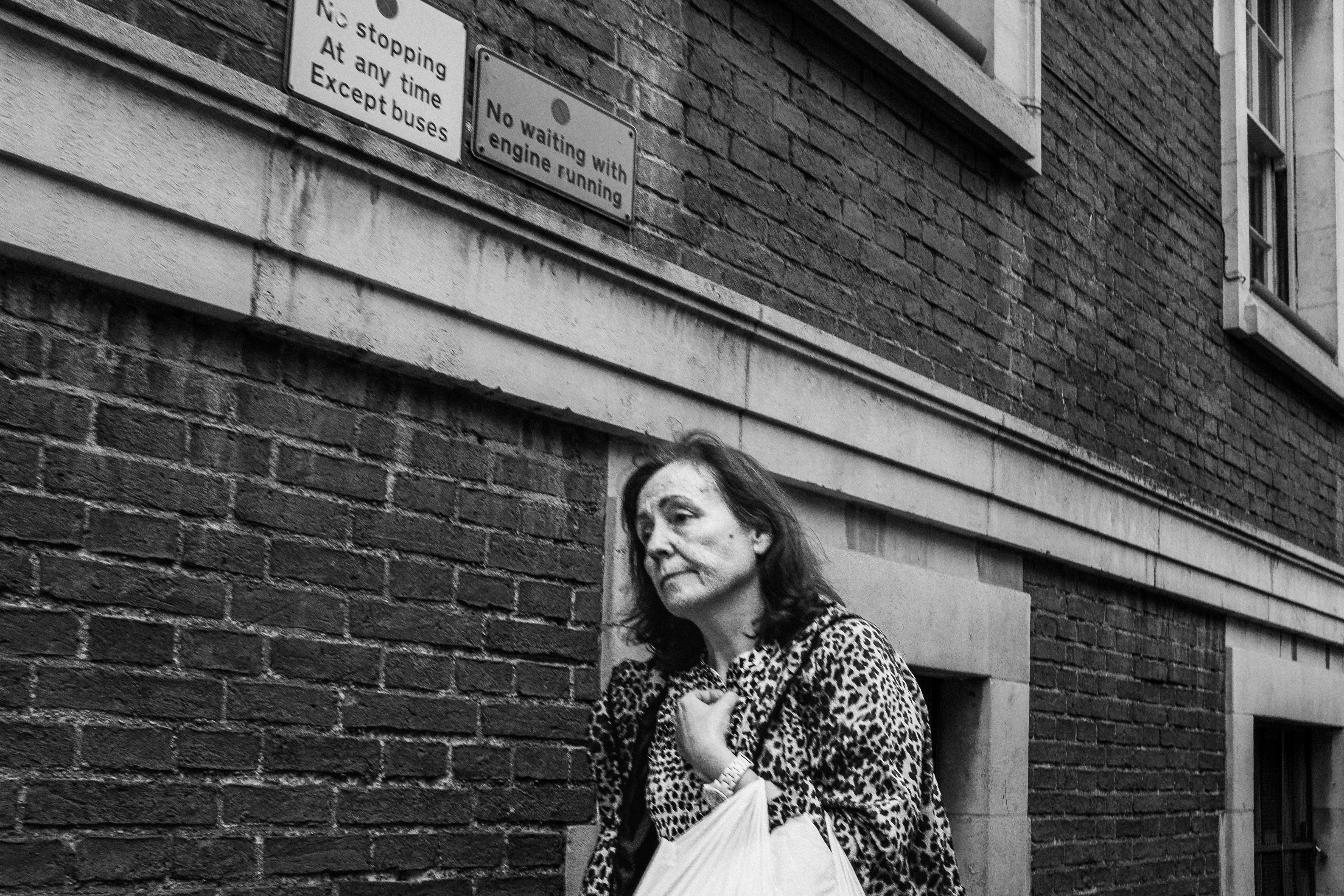 Woman in leopard print coat on a brick street corner
