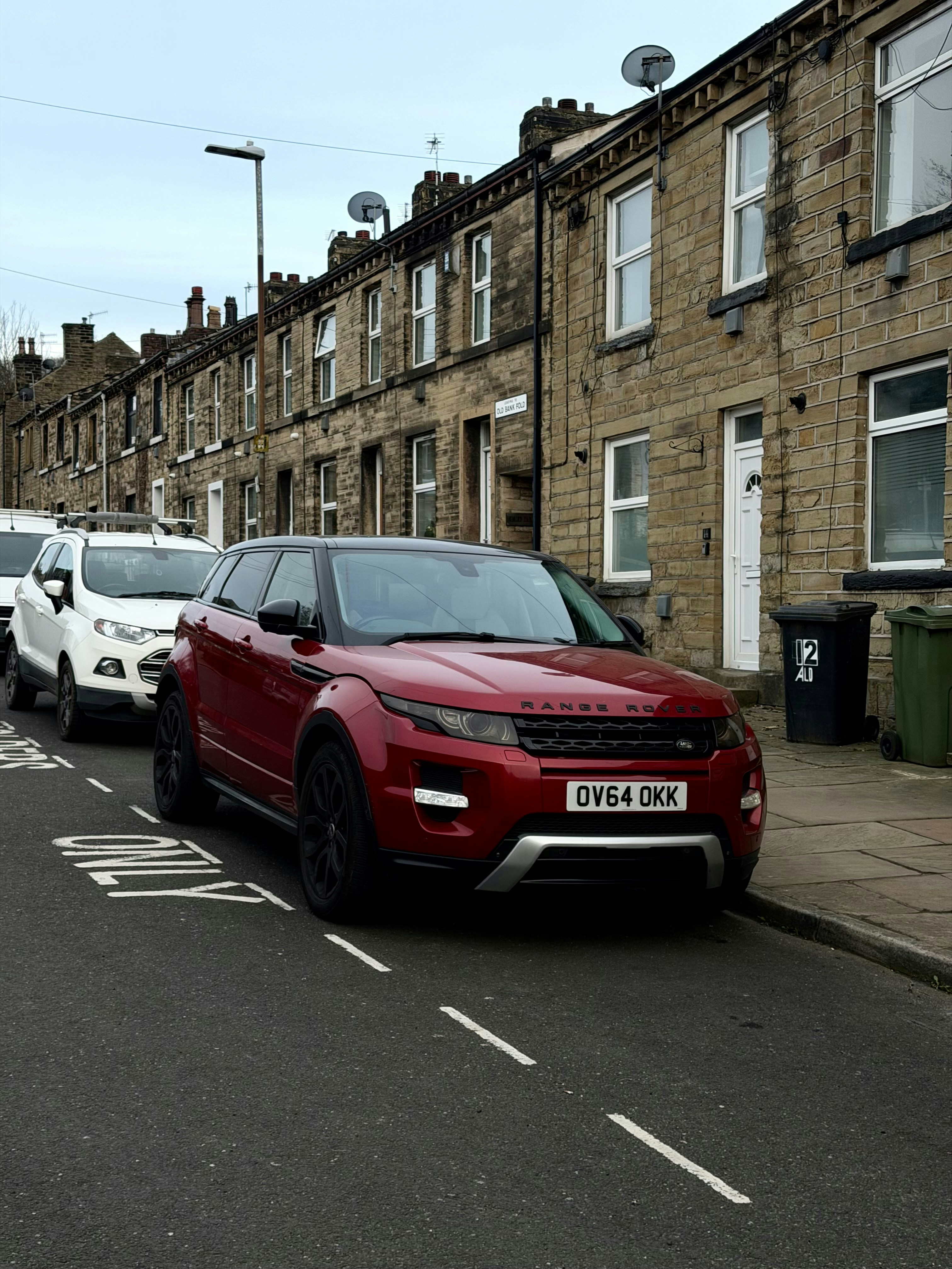 Red Range Rover Dominates a Quiet Street of Terraced Homes