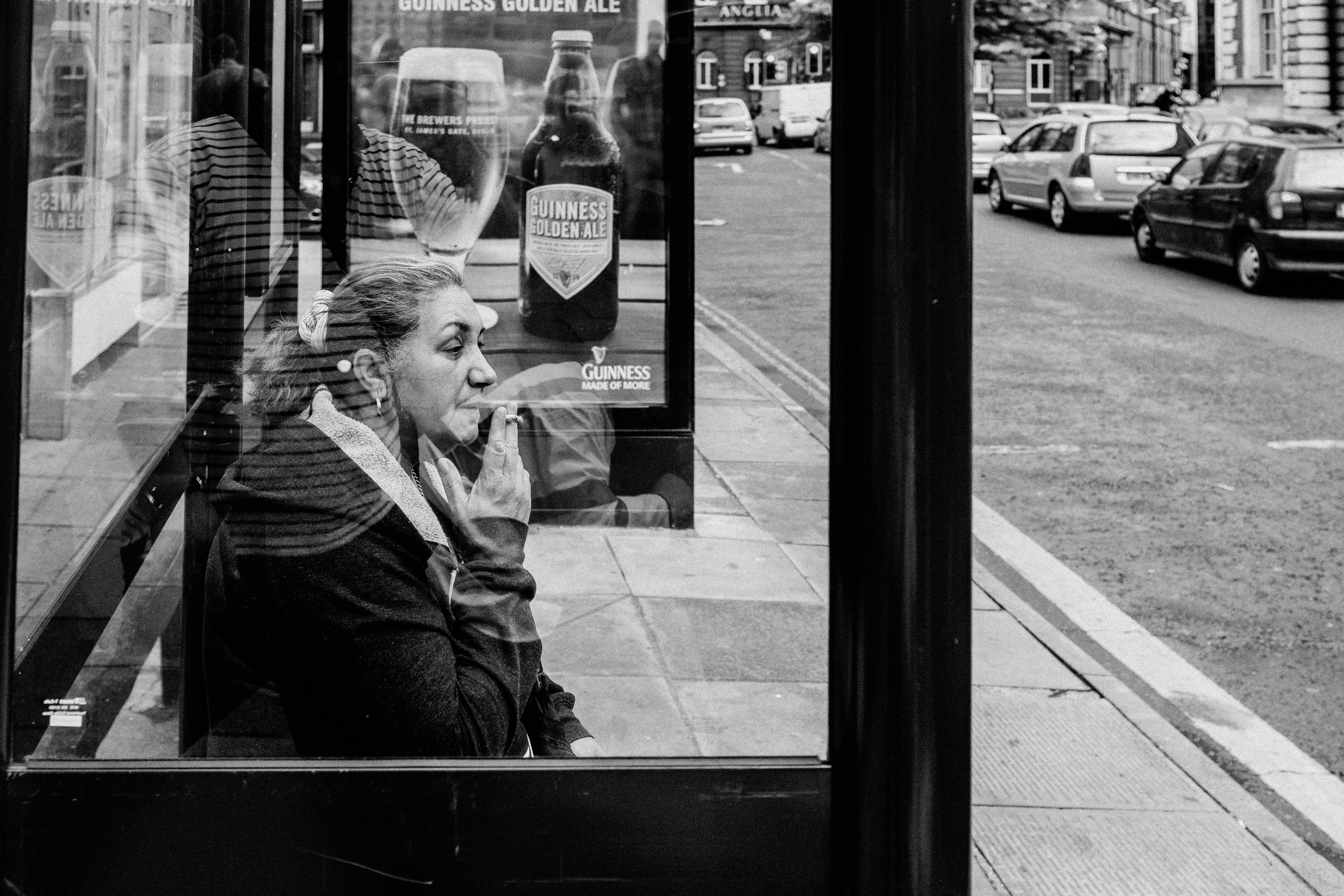 Waiting silhouette: a woman in a bus shelter lost in smoke and thought