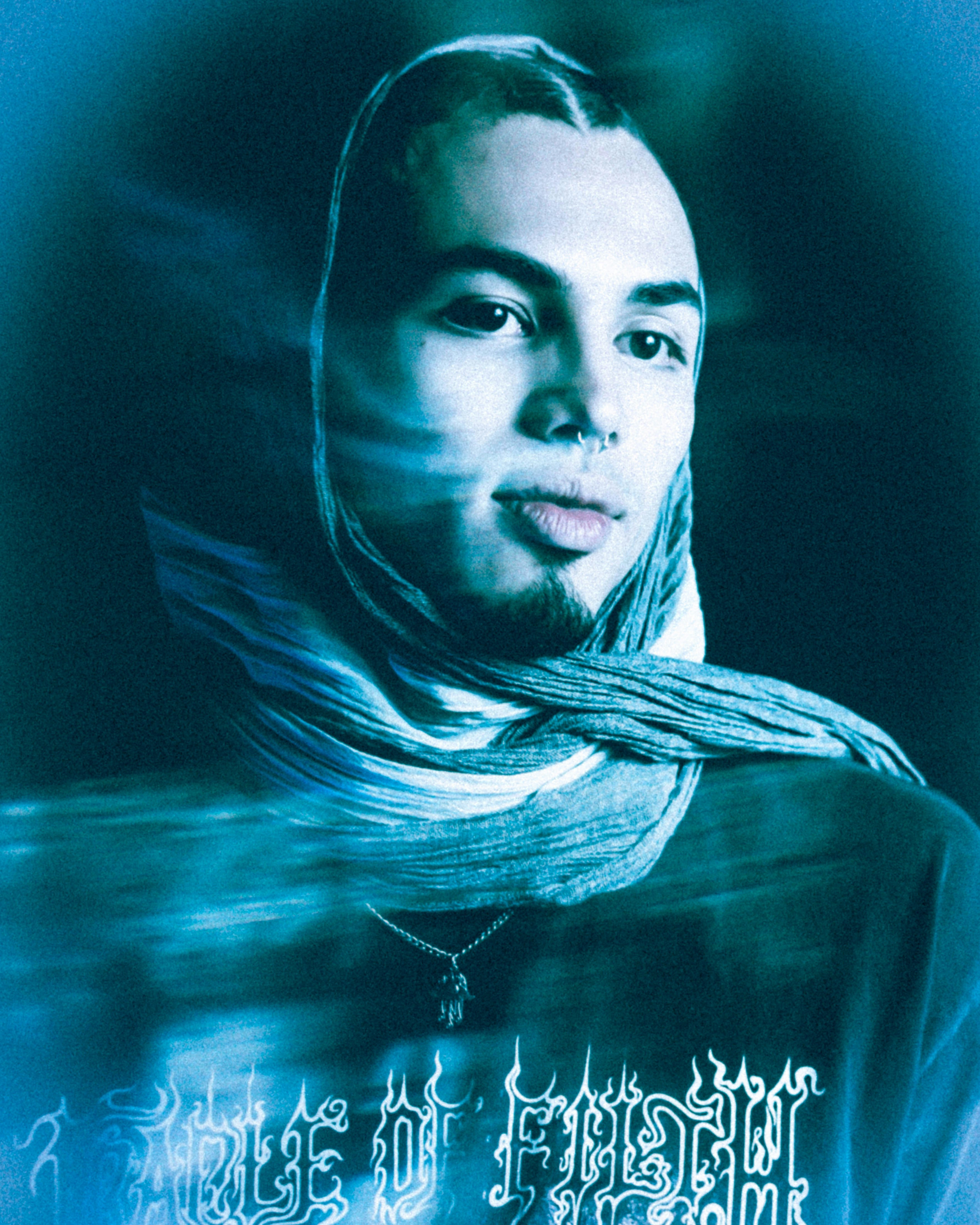 Blue-tinted portrait of a contemplative man wrapped in a scarf