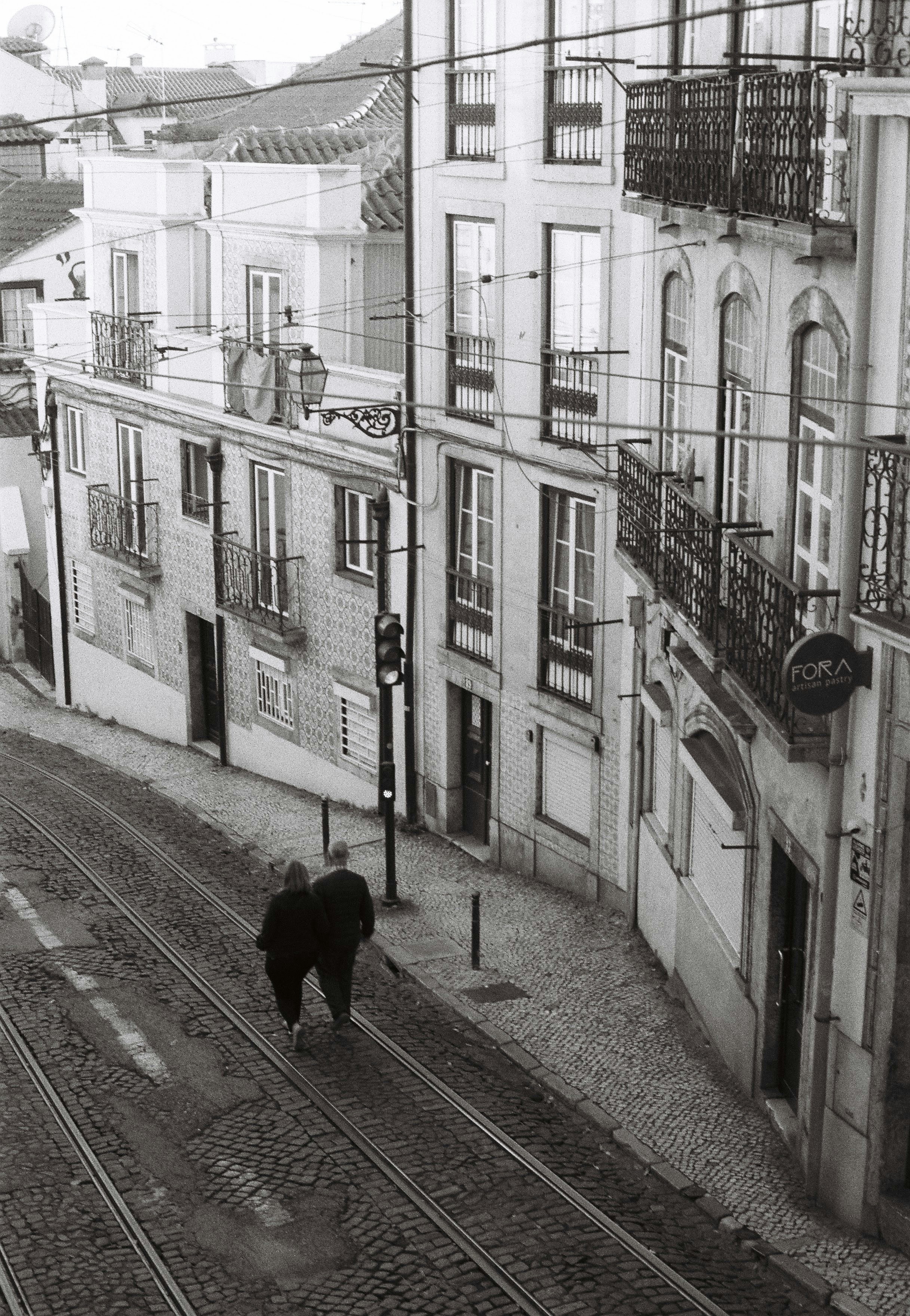 Urban Ascent: Two Figures Treading a Cobblestone Spine