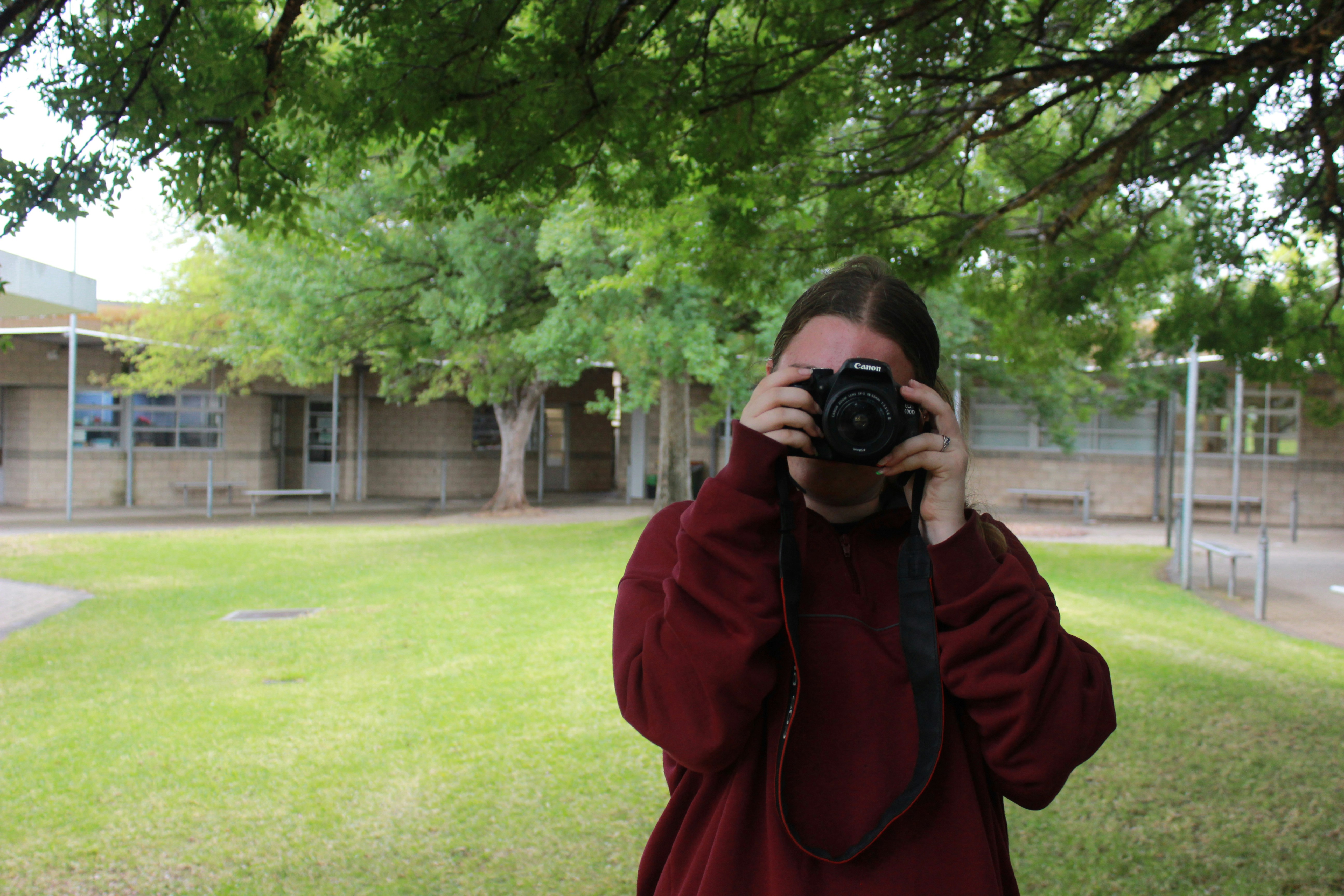 Front-Focused Portrait: A Youth with a Camera in the Campus Quad