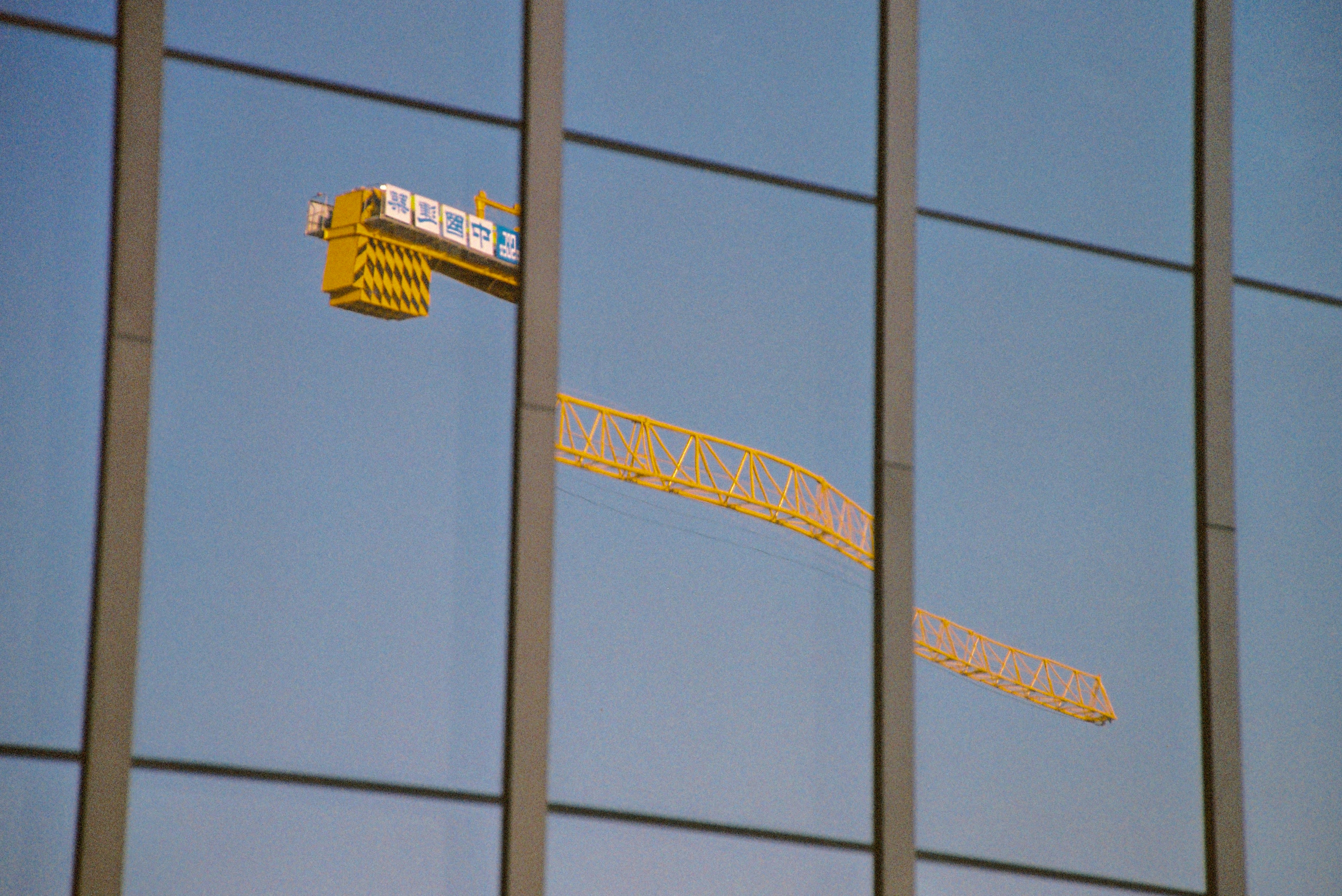 Crane Beams Across Reflected Glass