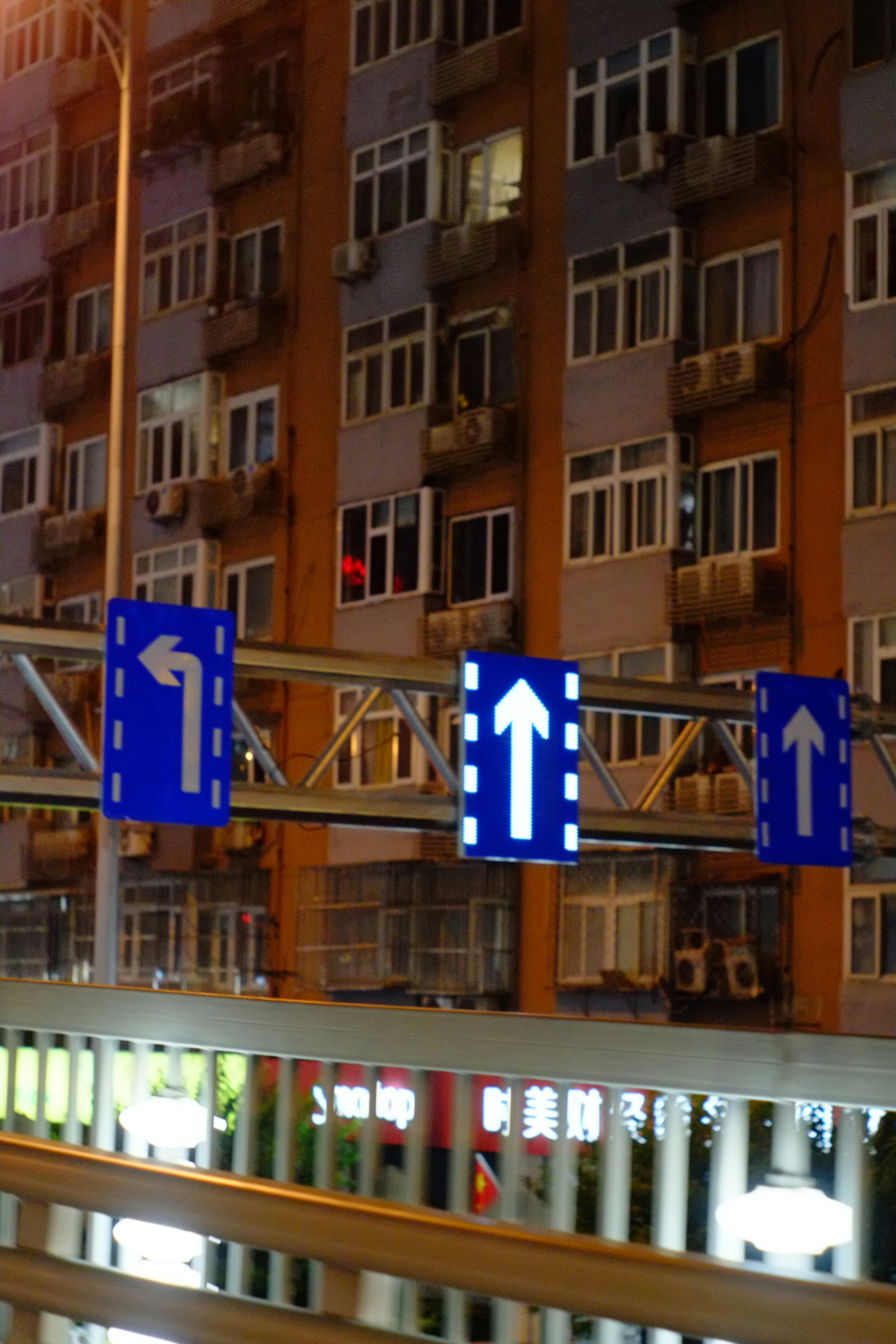 Neon Arrows Over a Night-Strewn City Facade