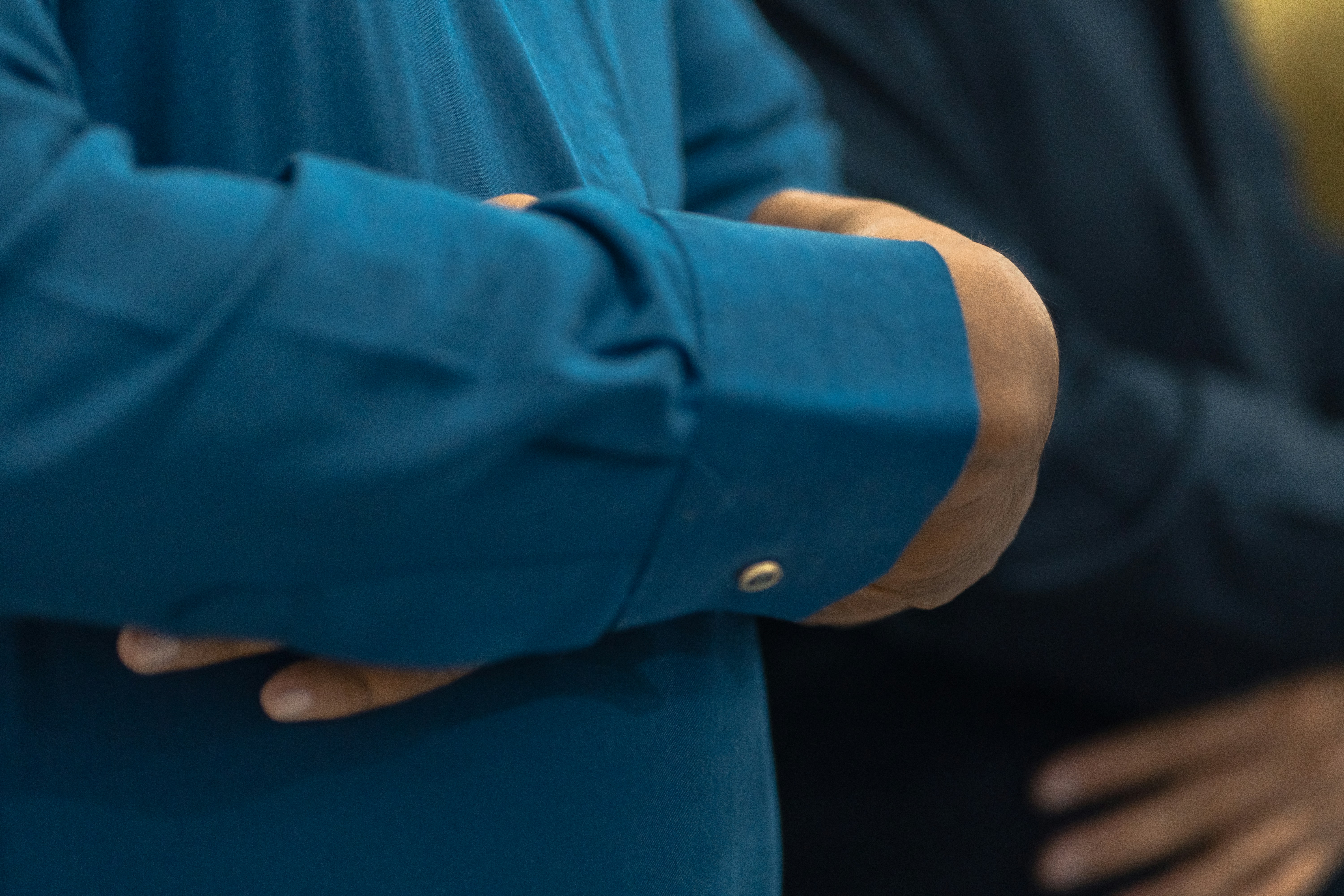 Crossed Arms in Blue: A Quiet Moment in the Crowd