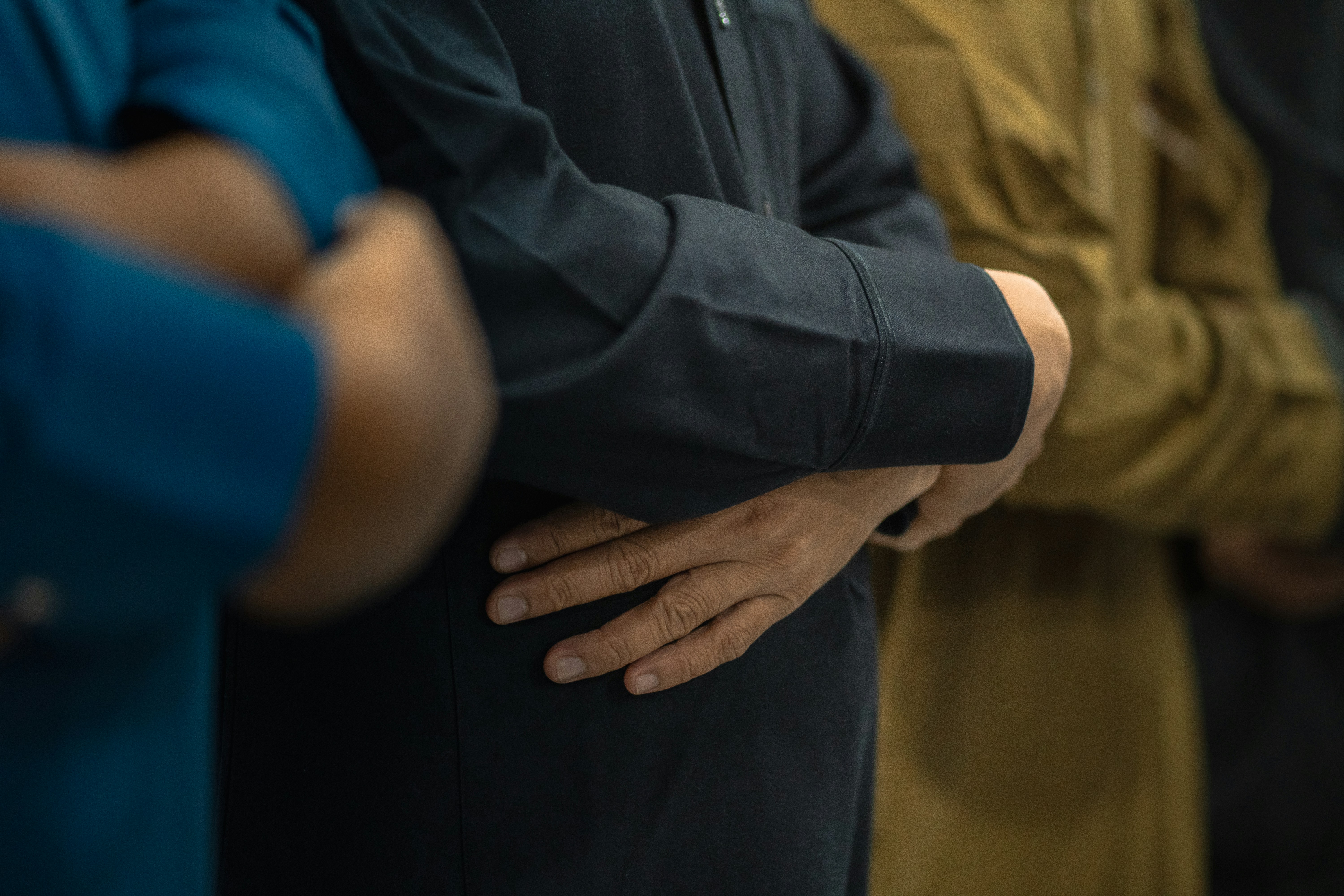 Armed Stillness: A row of folded arms in quiet formation