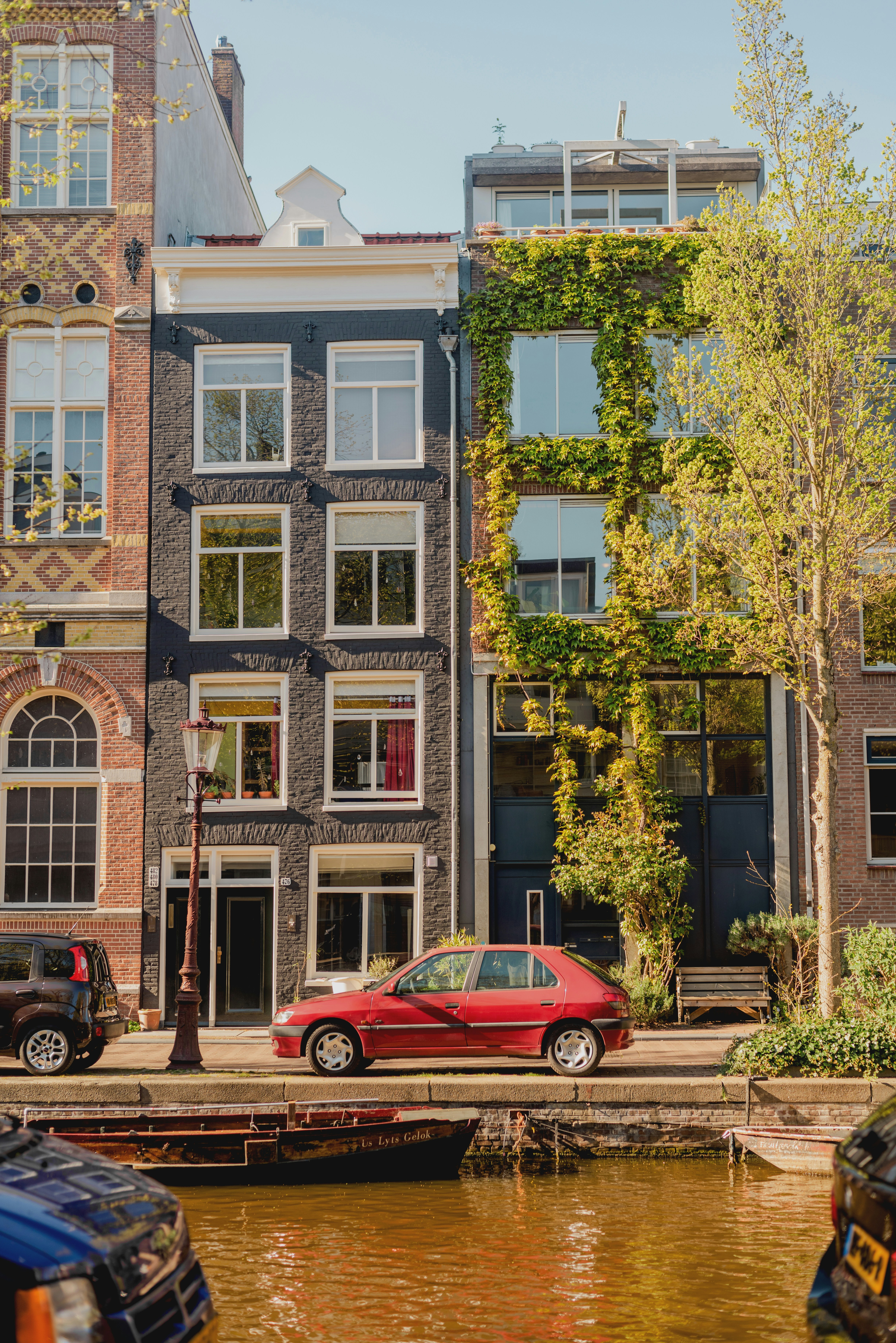 Brick Facade Ballet: Sunlit Canalfront in Amsterdam