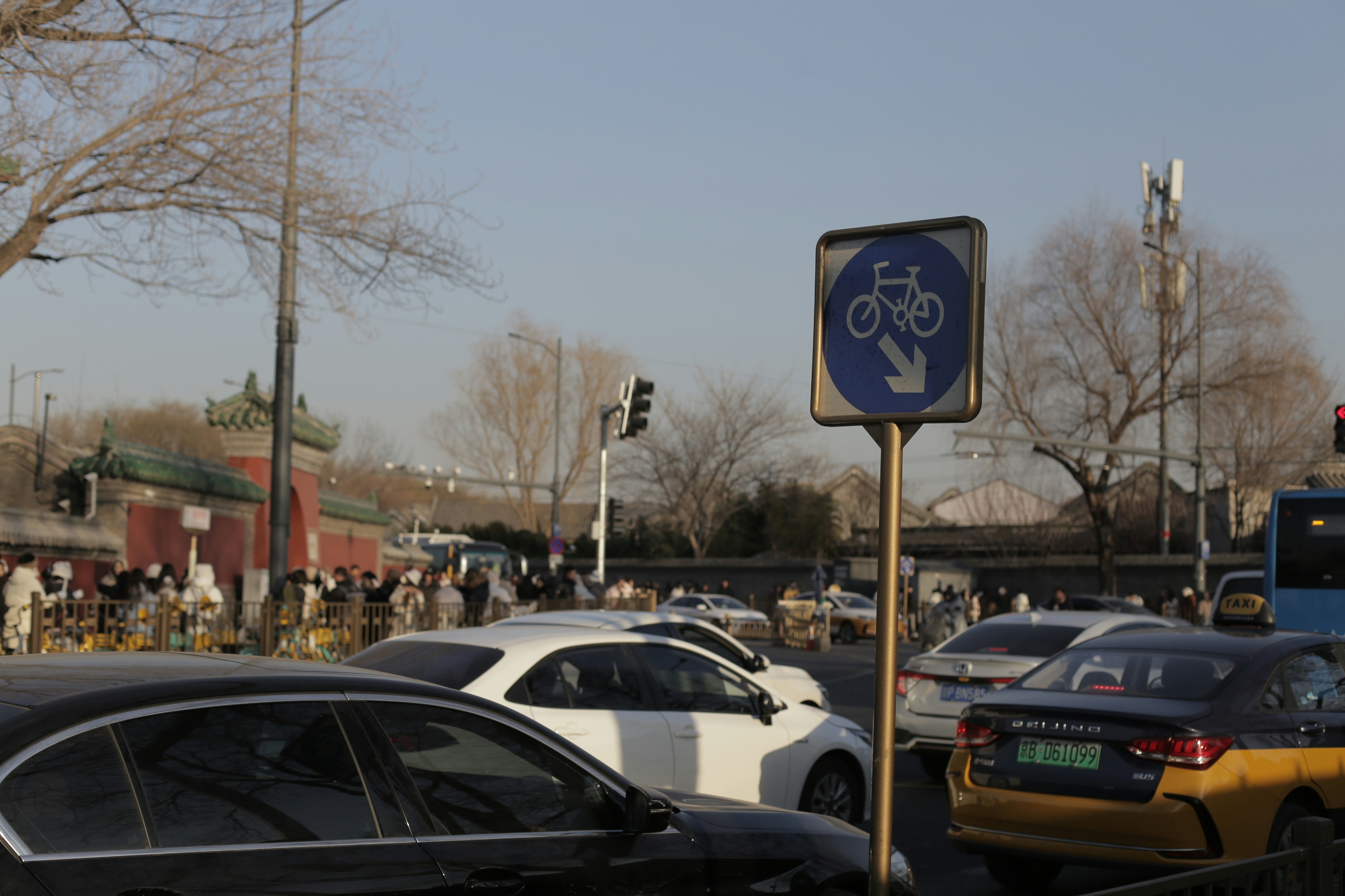 Crowded City Crossing: A Bicycle Sign Guards the Flow