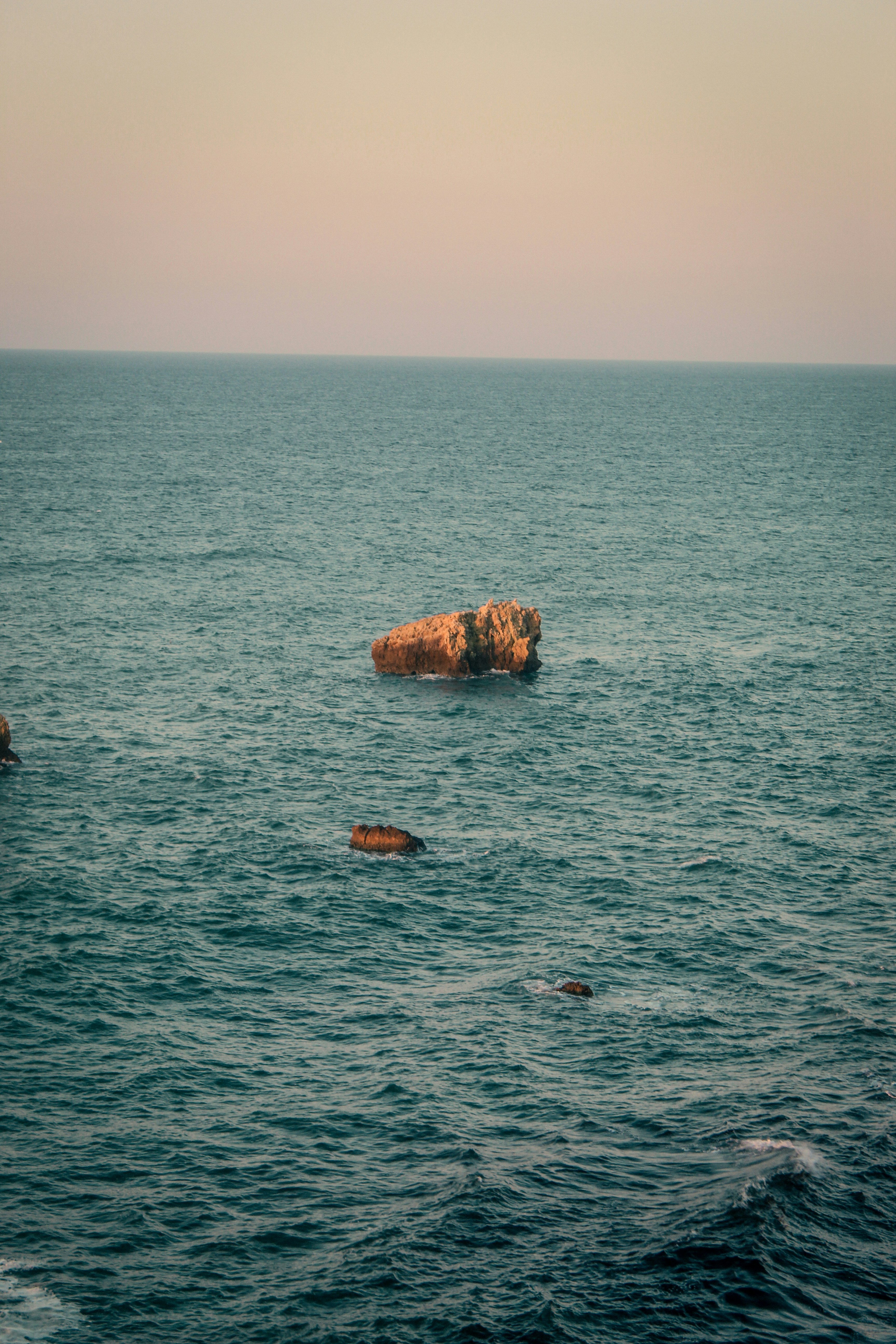 Sea Sentinel: A Lone Rock Holds Its Ground at Dusk