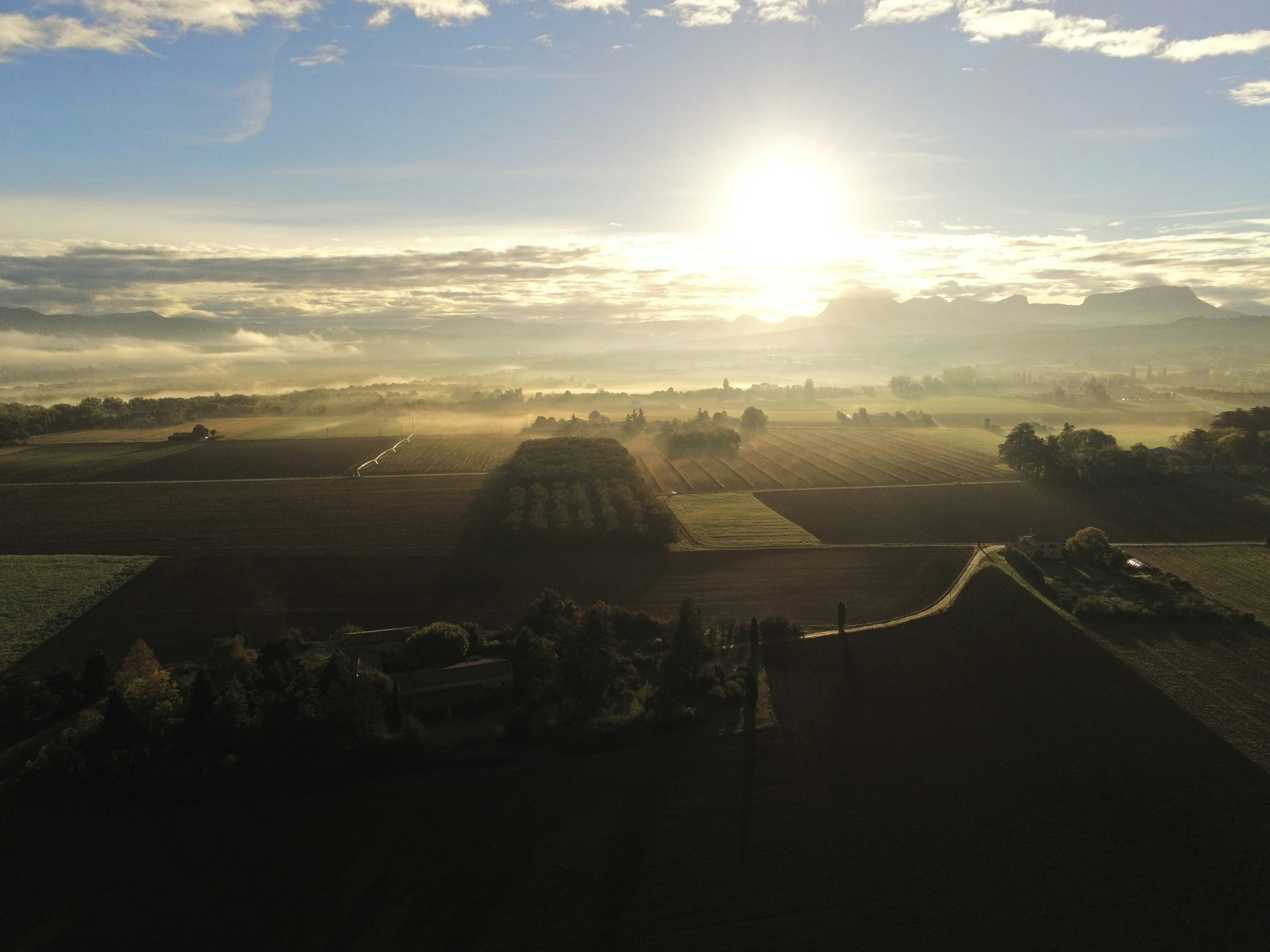 Dawn over Tiled Fields: Golden Light Over Quiet Valley Roads