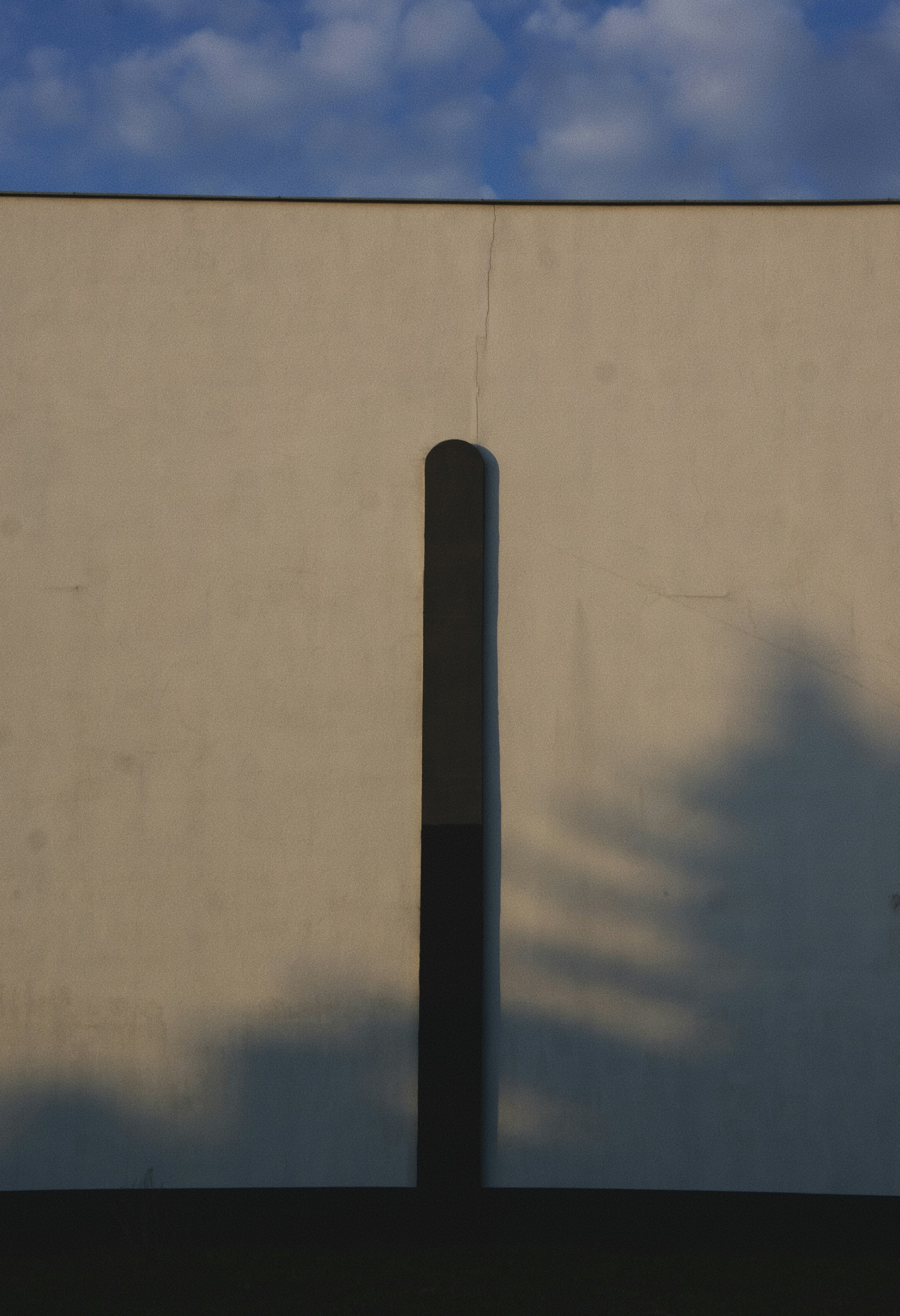 Vertical Shadow Gate in a Sunlit Wall
