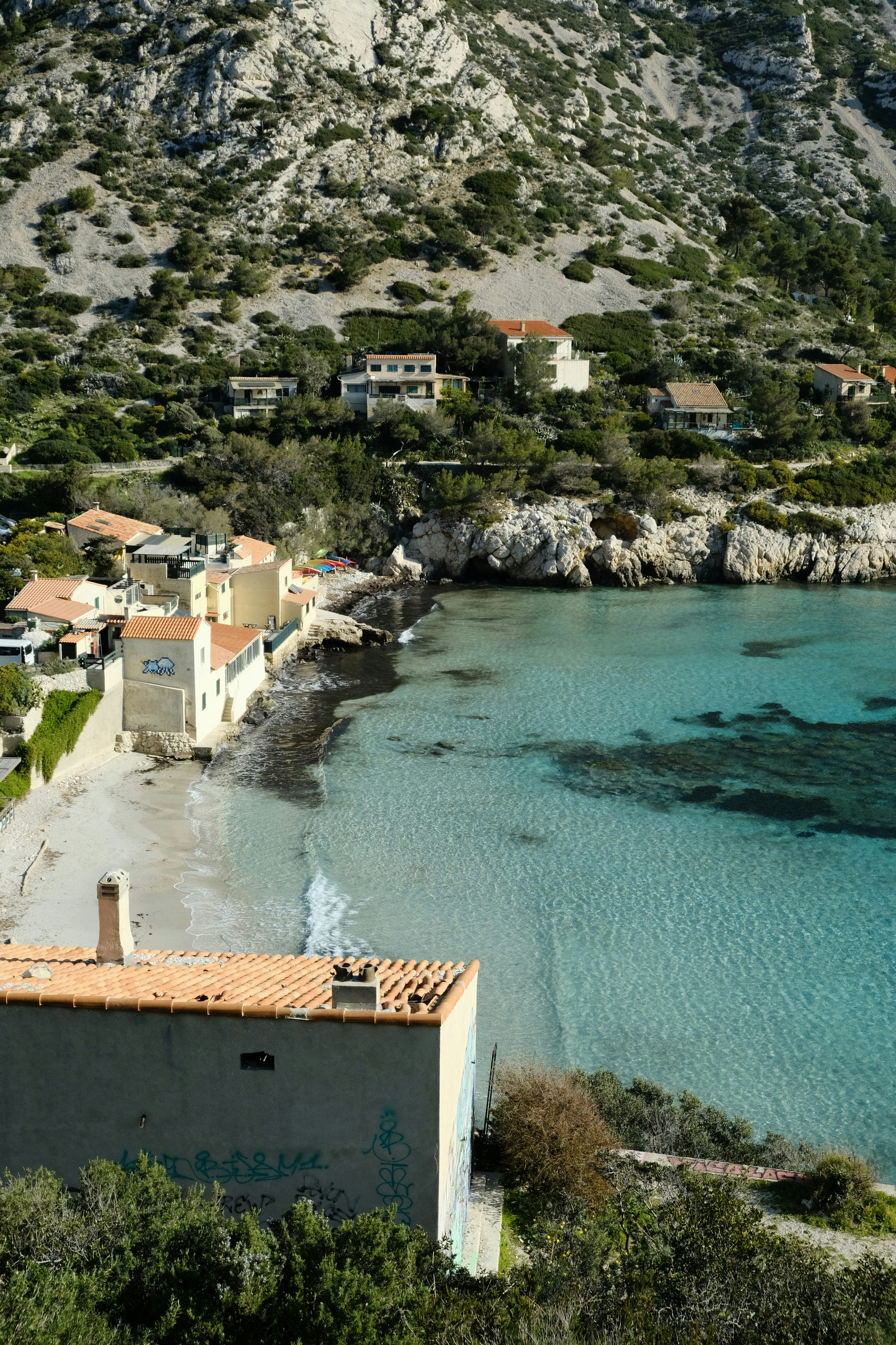 Sunlit cove village perched along turquoise waters