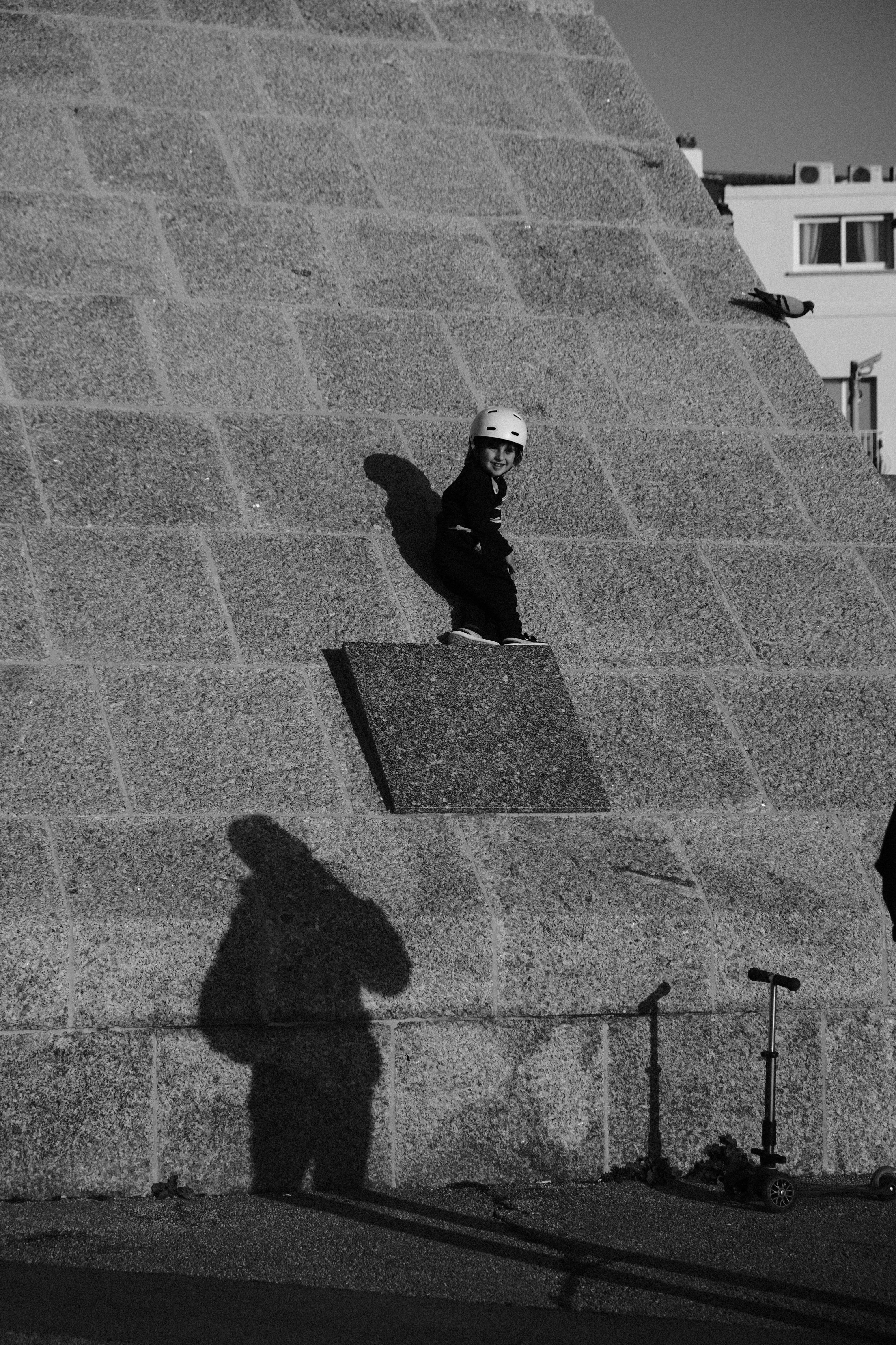 Rooftop Parkour: Child on a Concrete Slab Amid Urban Slope