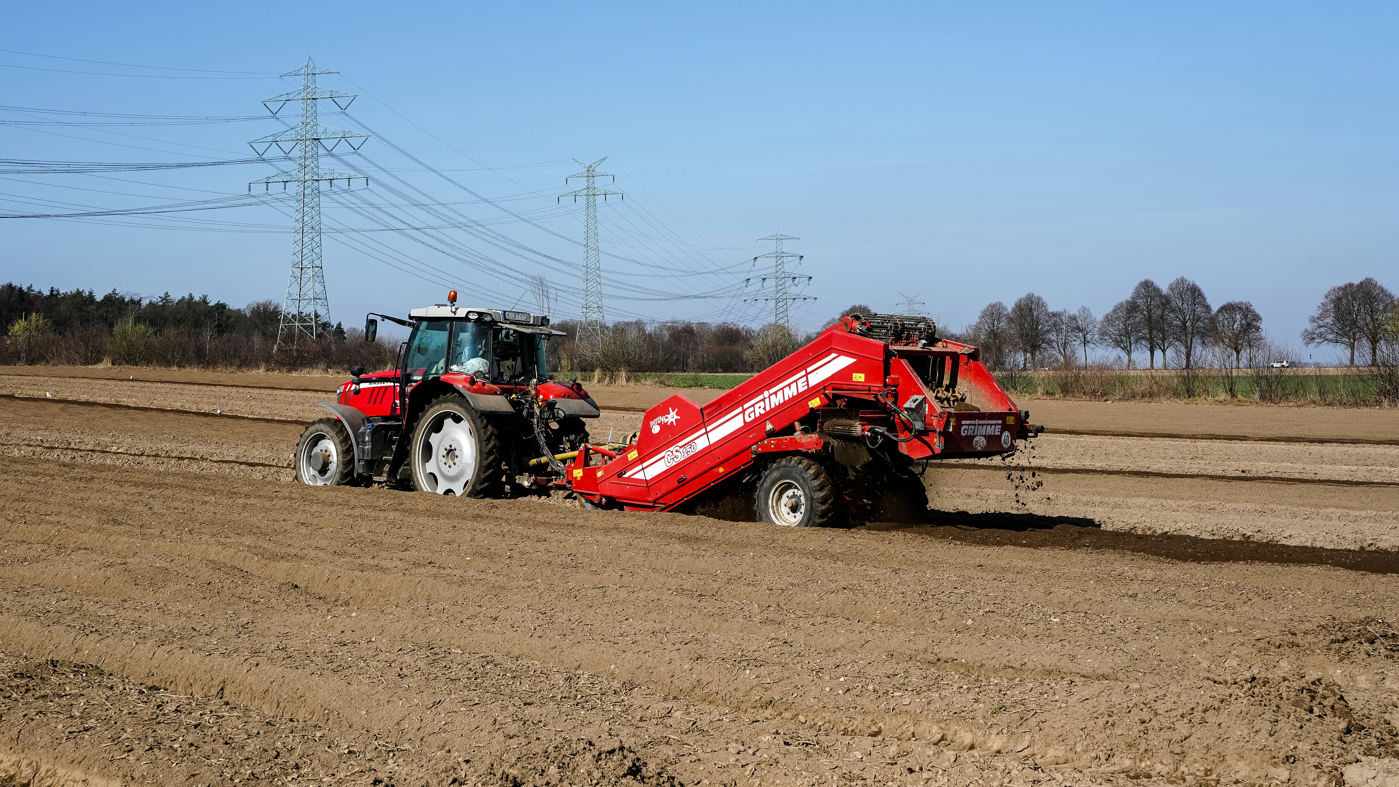Red Tractor and PTO-Driven Harvester Taming a Quiet Field