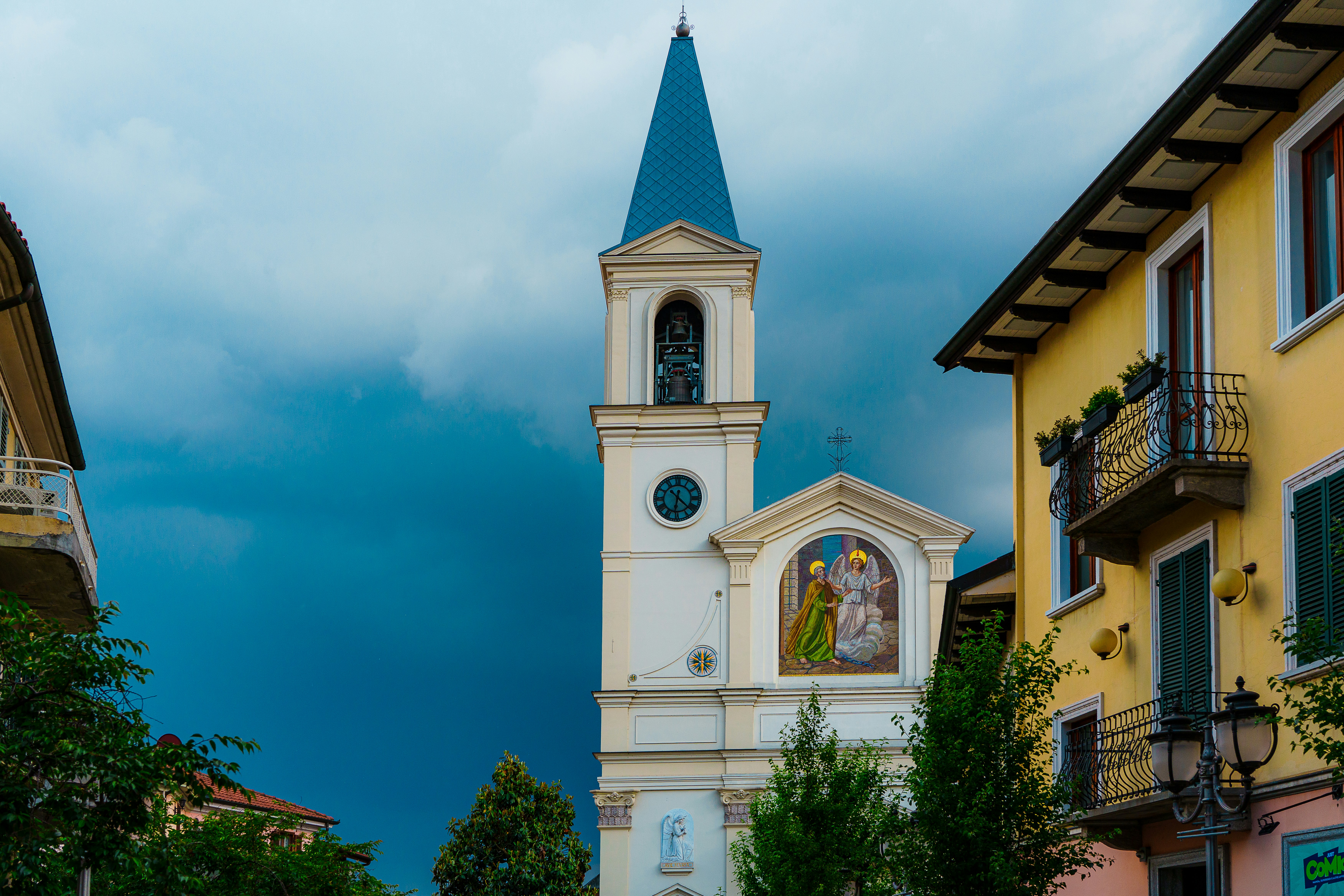 Church Steeple and Fresco Amid Colorful Plaza Facades