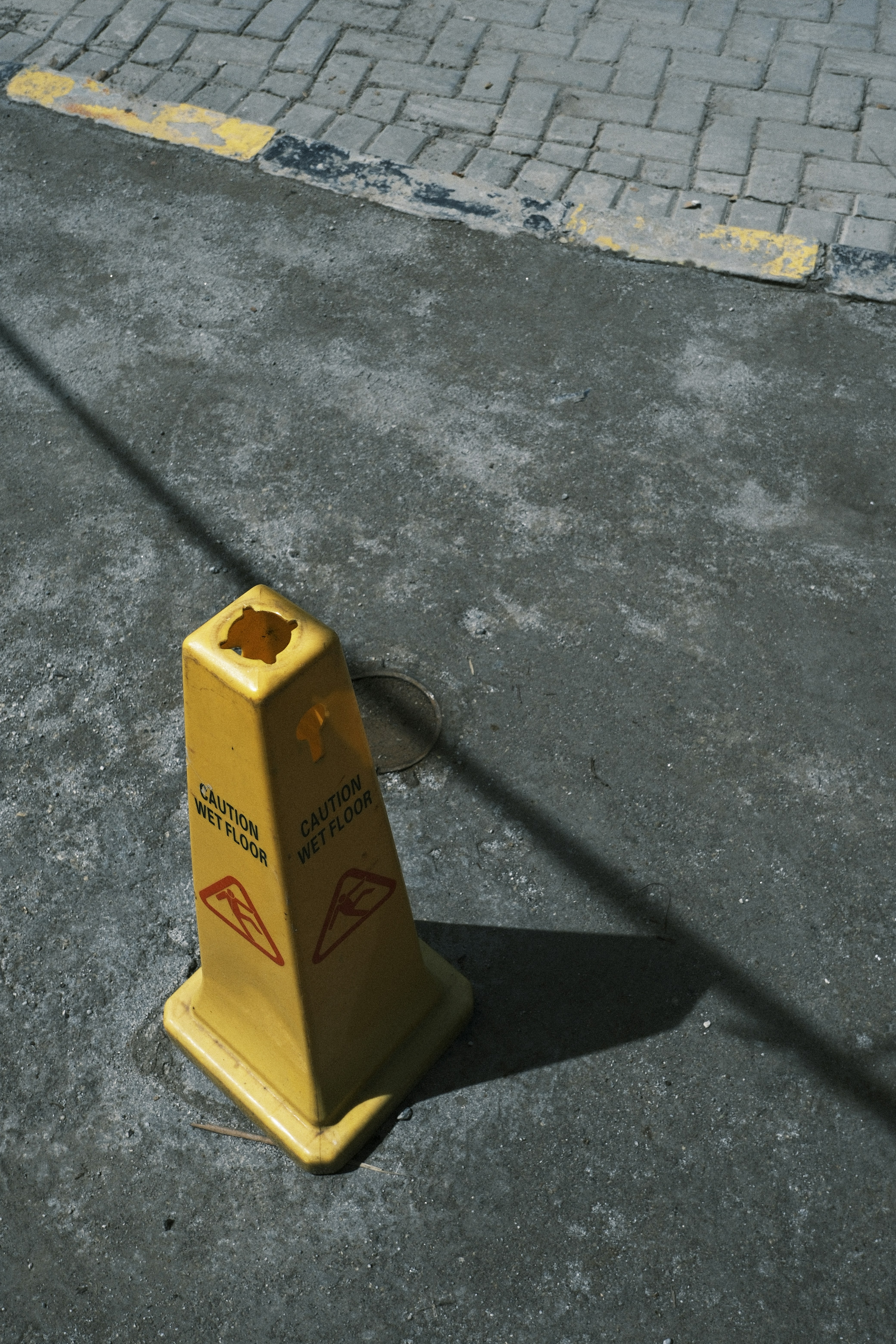 Yellow Caution Tower on Weathered Pavement