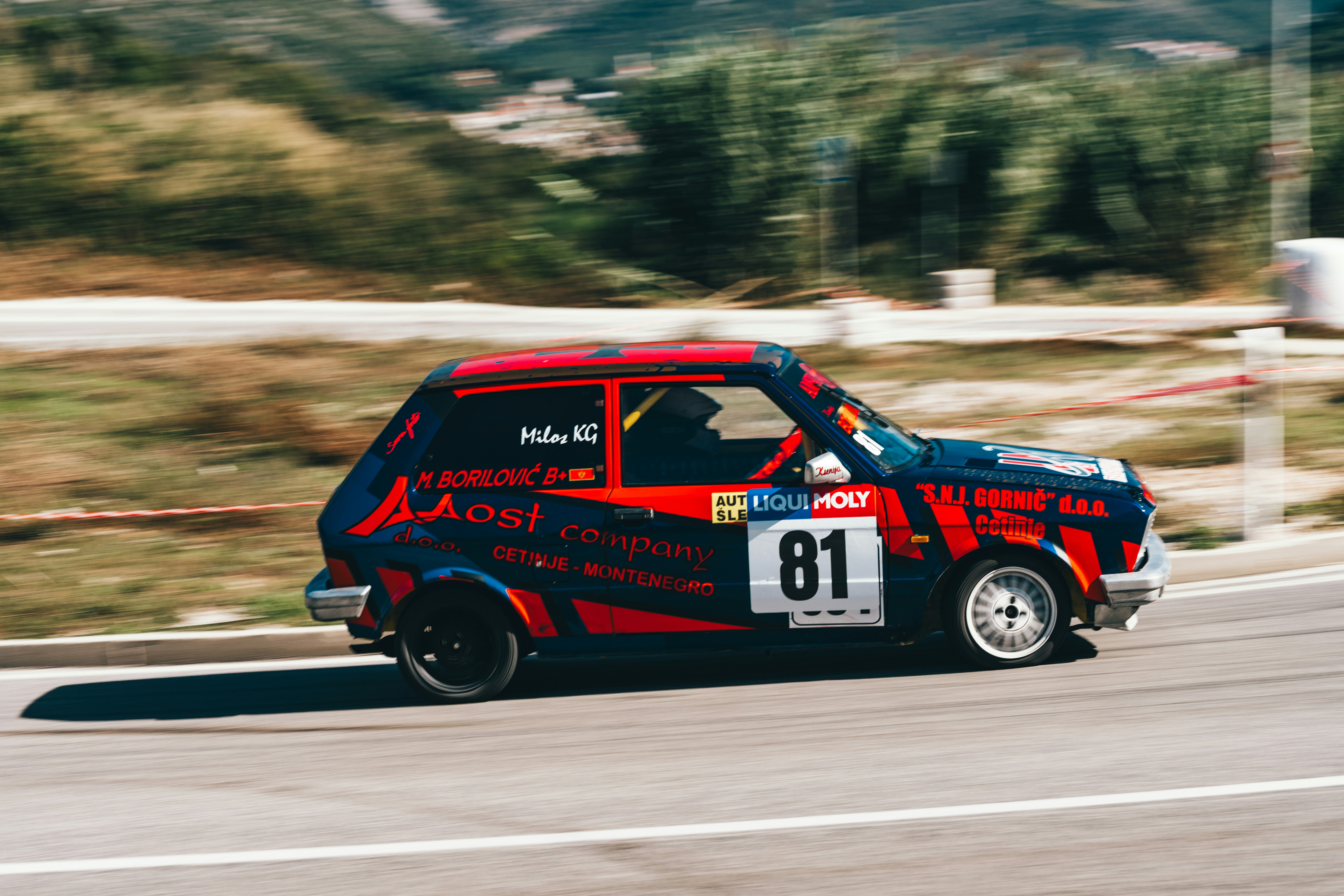 Racing Roof: A Red-and-Blue SUV Surges Past on Open Road