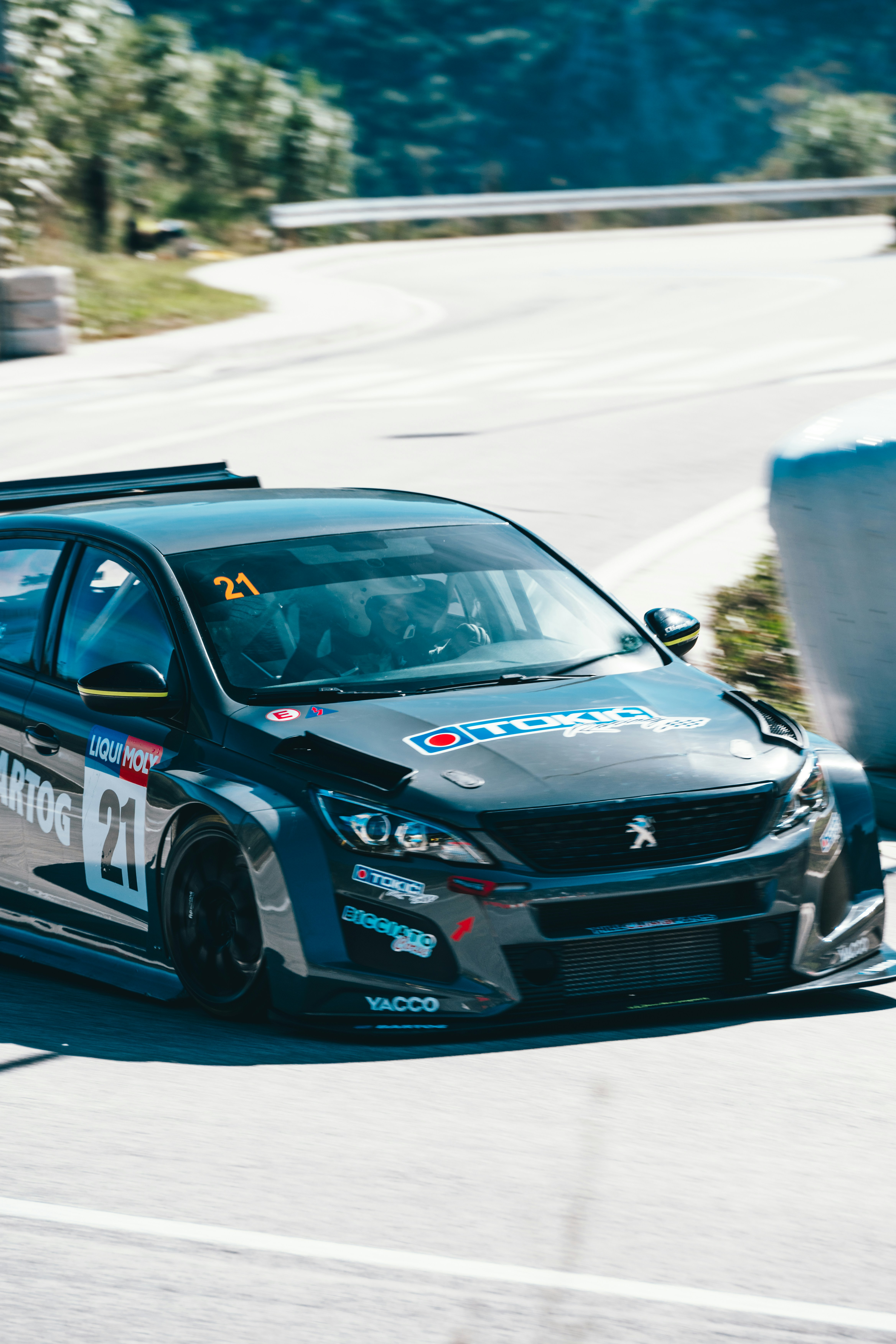 Chasing the Curve: A race-car bursts through a winding mountain pass