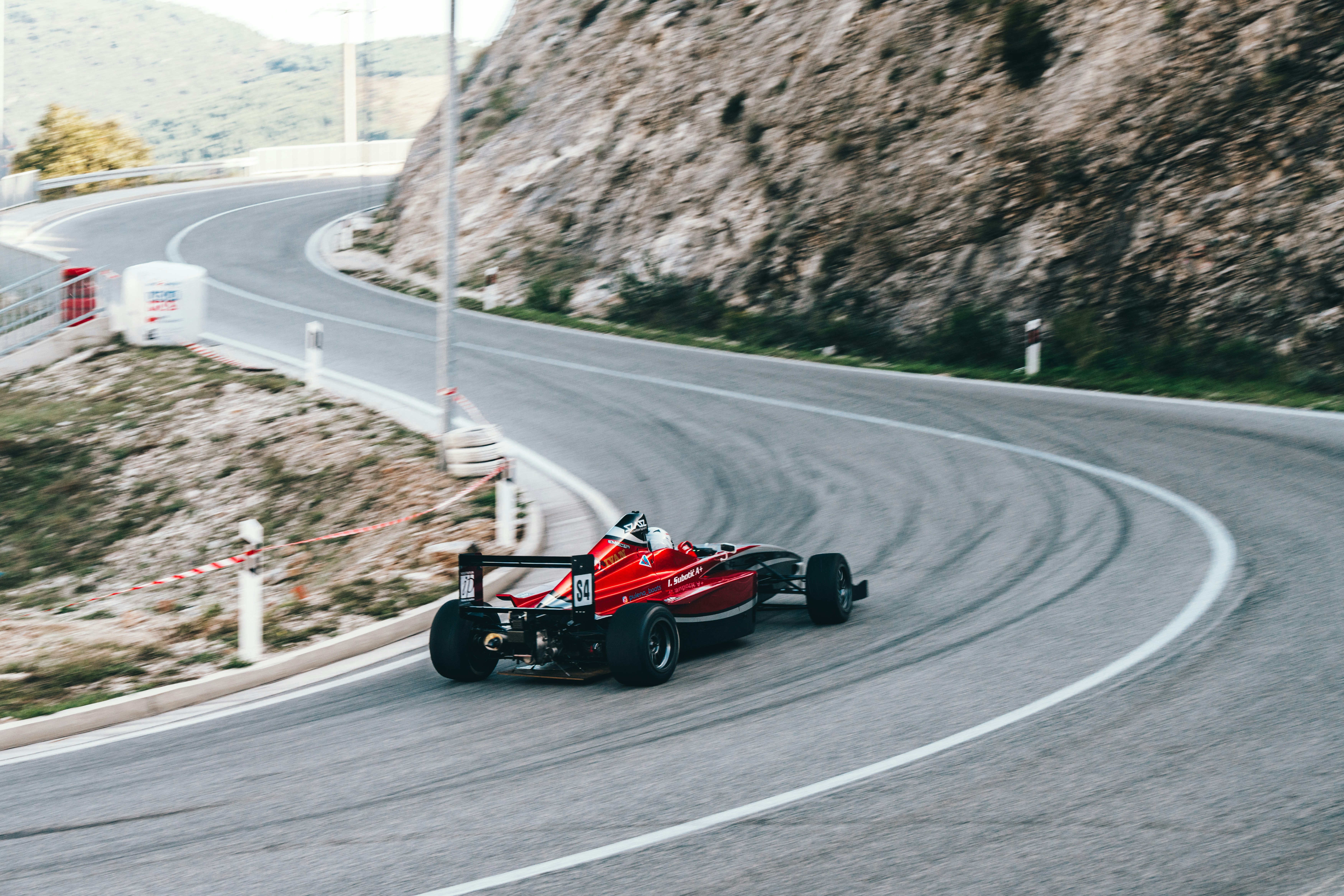 Red Formula Car Navigates a Winding Mountain Road