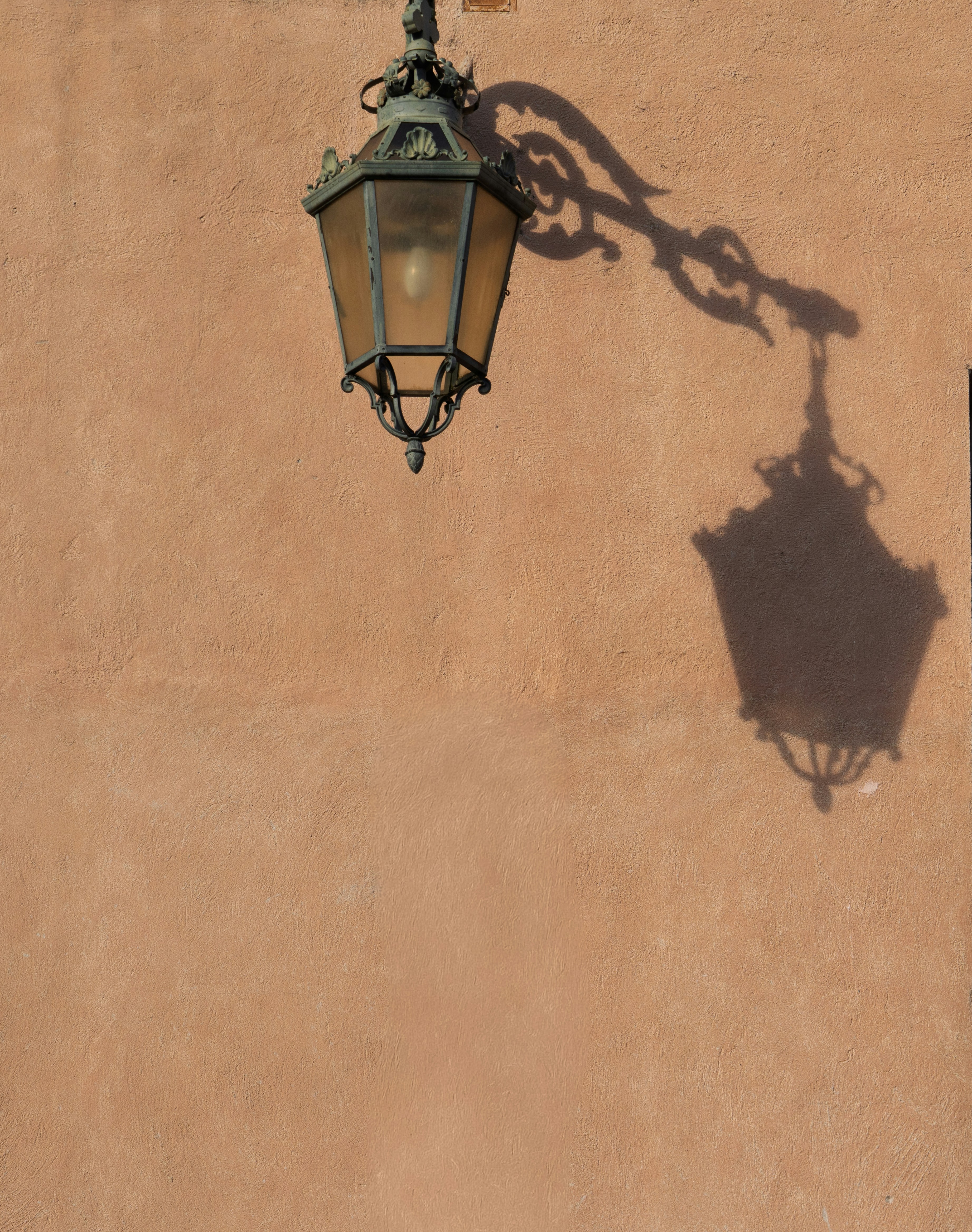 Shadowed Glow: A Vintage Street Lantern Casts Its Long Afternoon Shadow