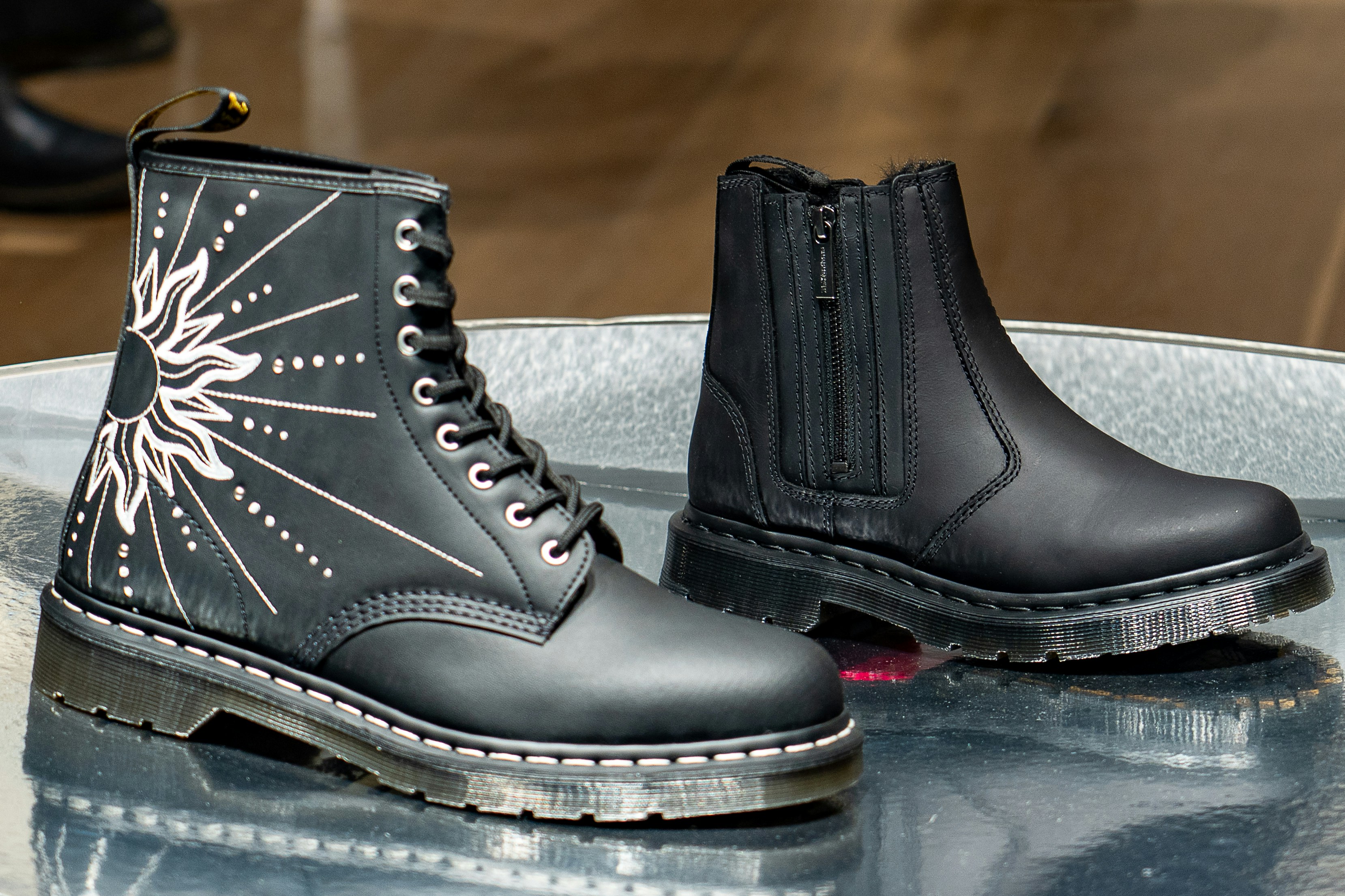 Sunburst Stitch Boots: Black Combat Pairs on a Metallic Surface