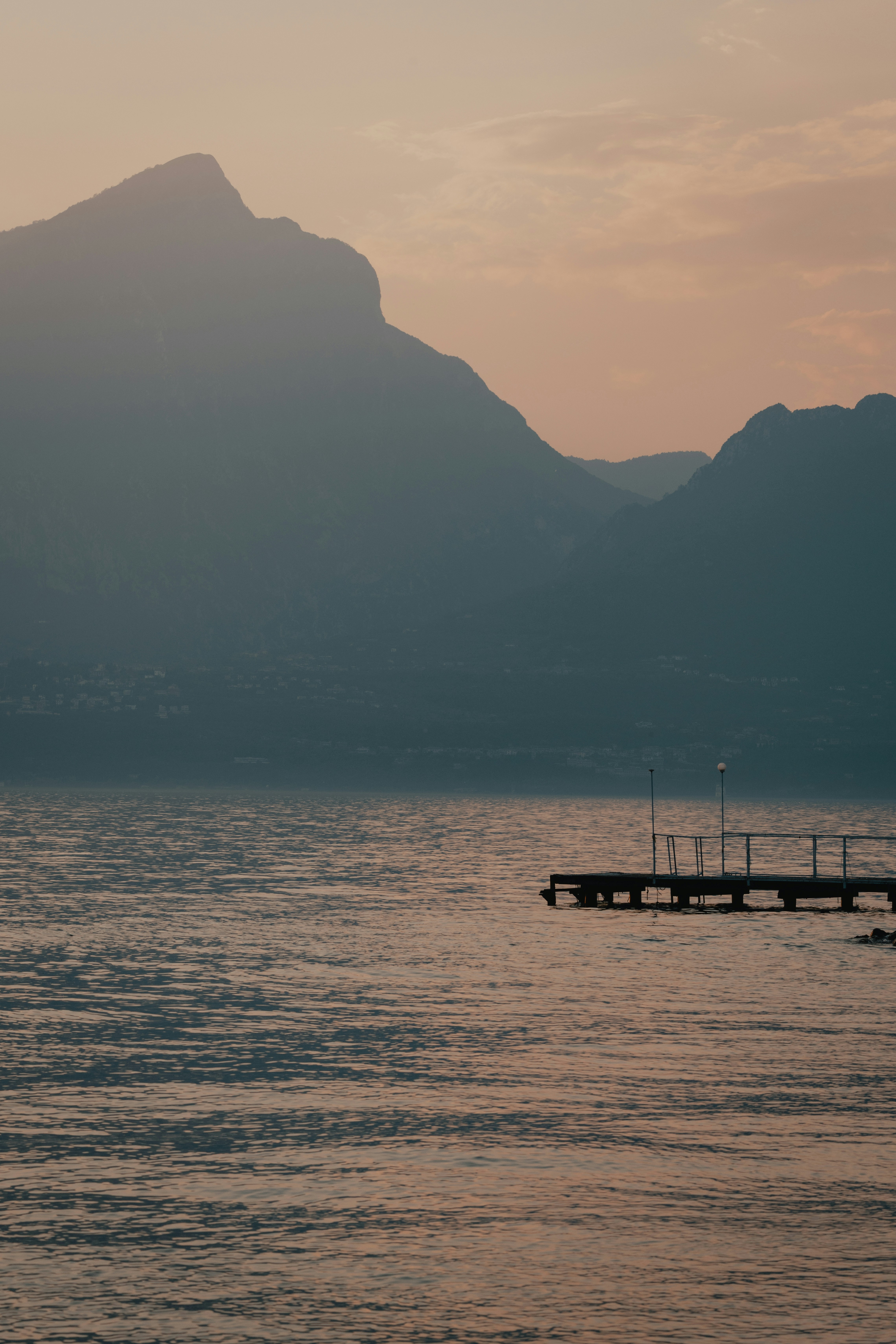 Silhouetted Pier at Dusk Over a Mountain Lake