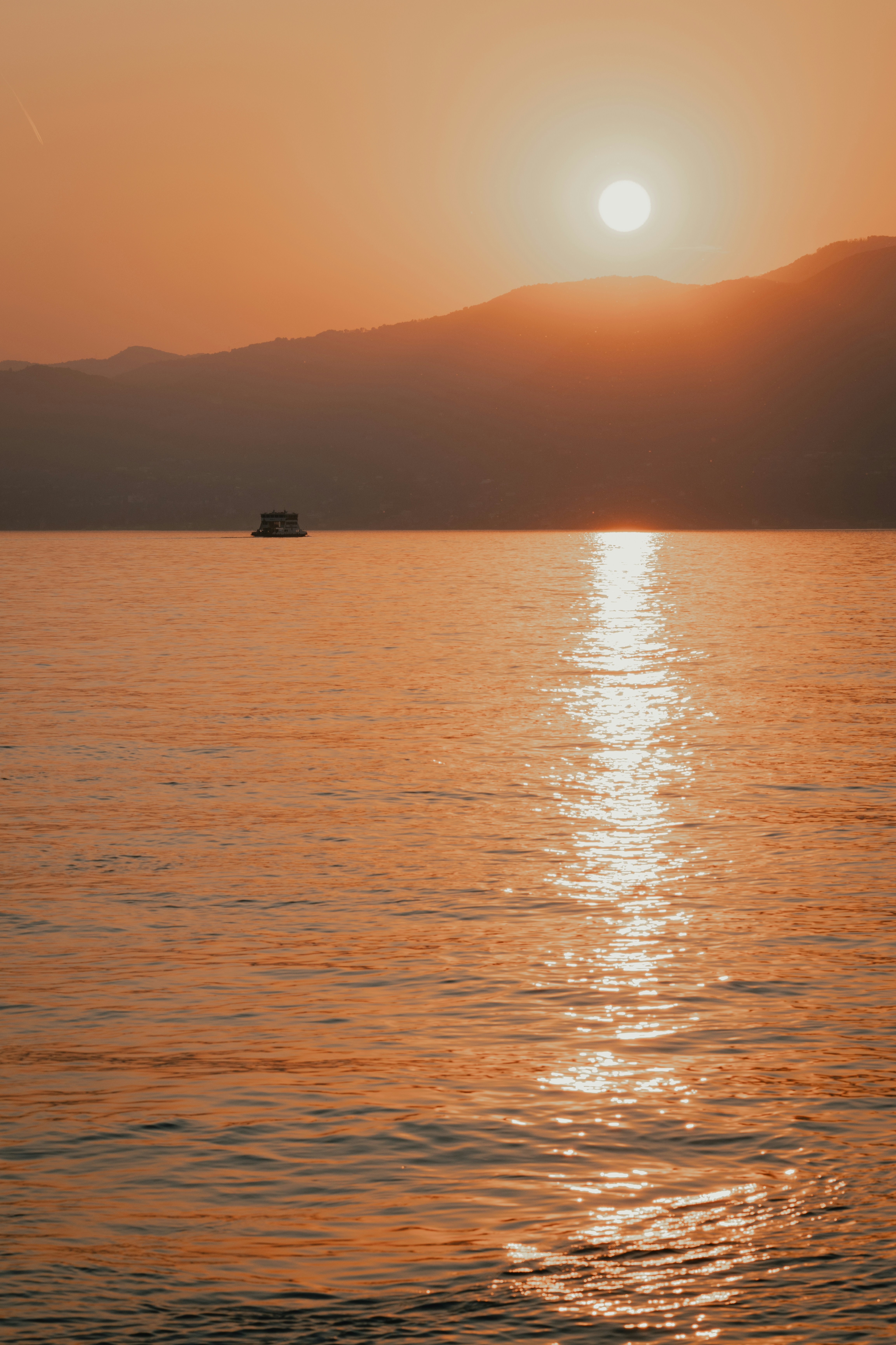 Sunlit Horizon: A Quiet Boat beneath an Amber Sky