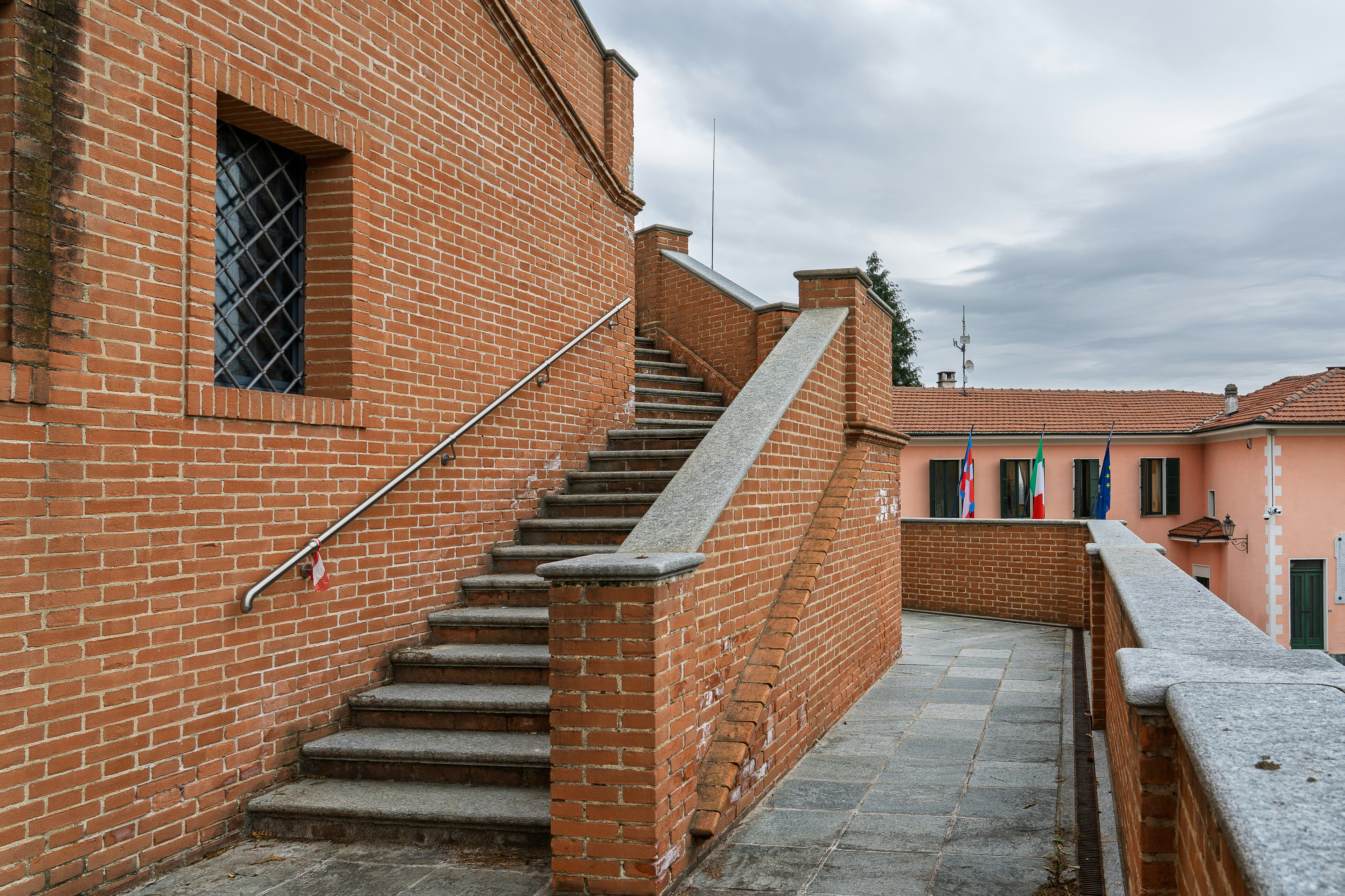 Terracotta Staircase: The Ascent Along a Brick Courtyard