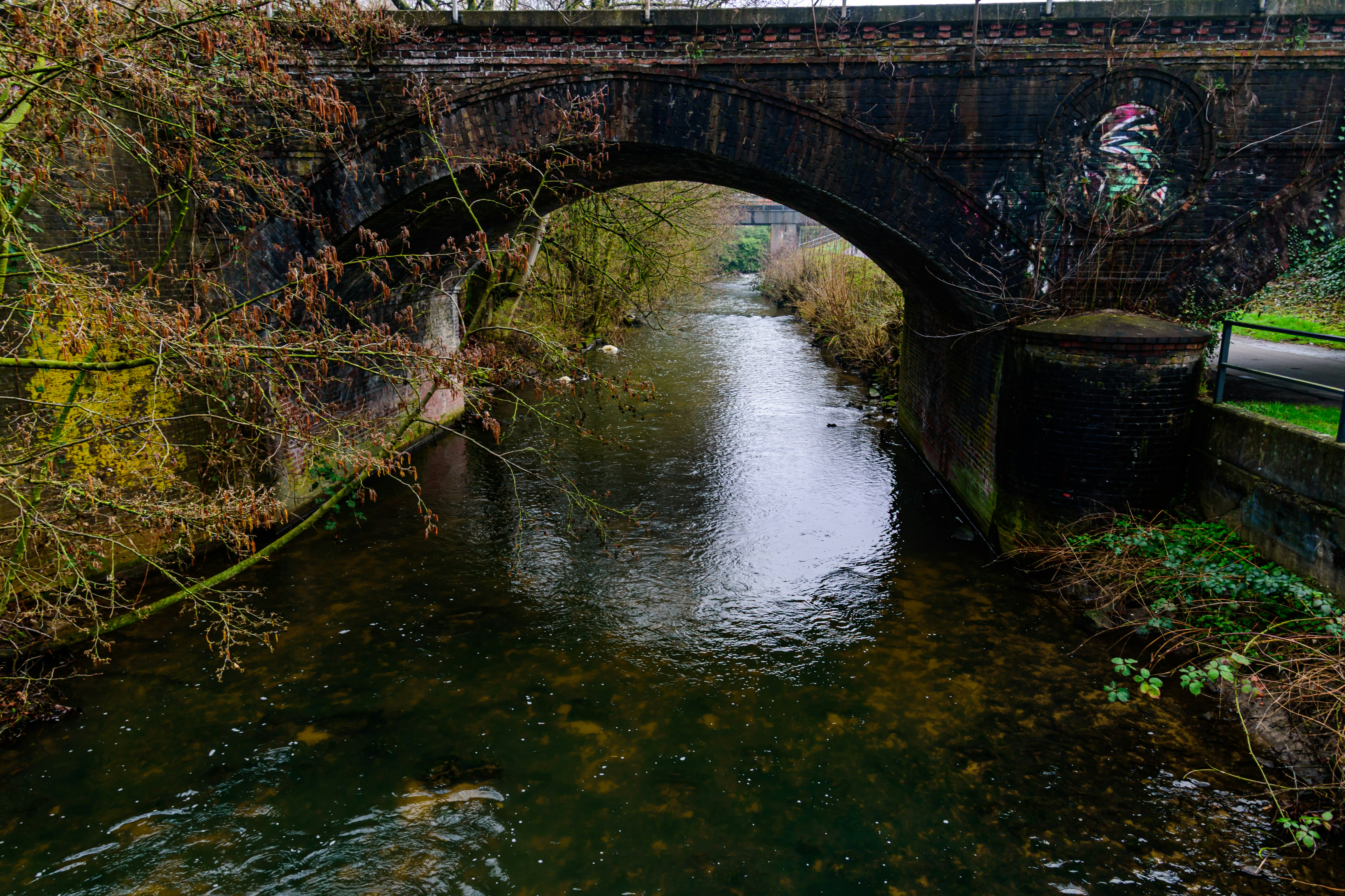 Old Arch Over Silent River: Graffiti Meets Gravity