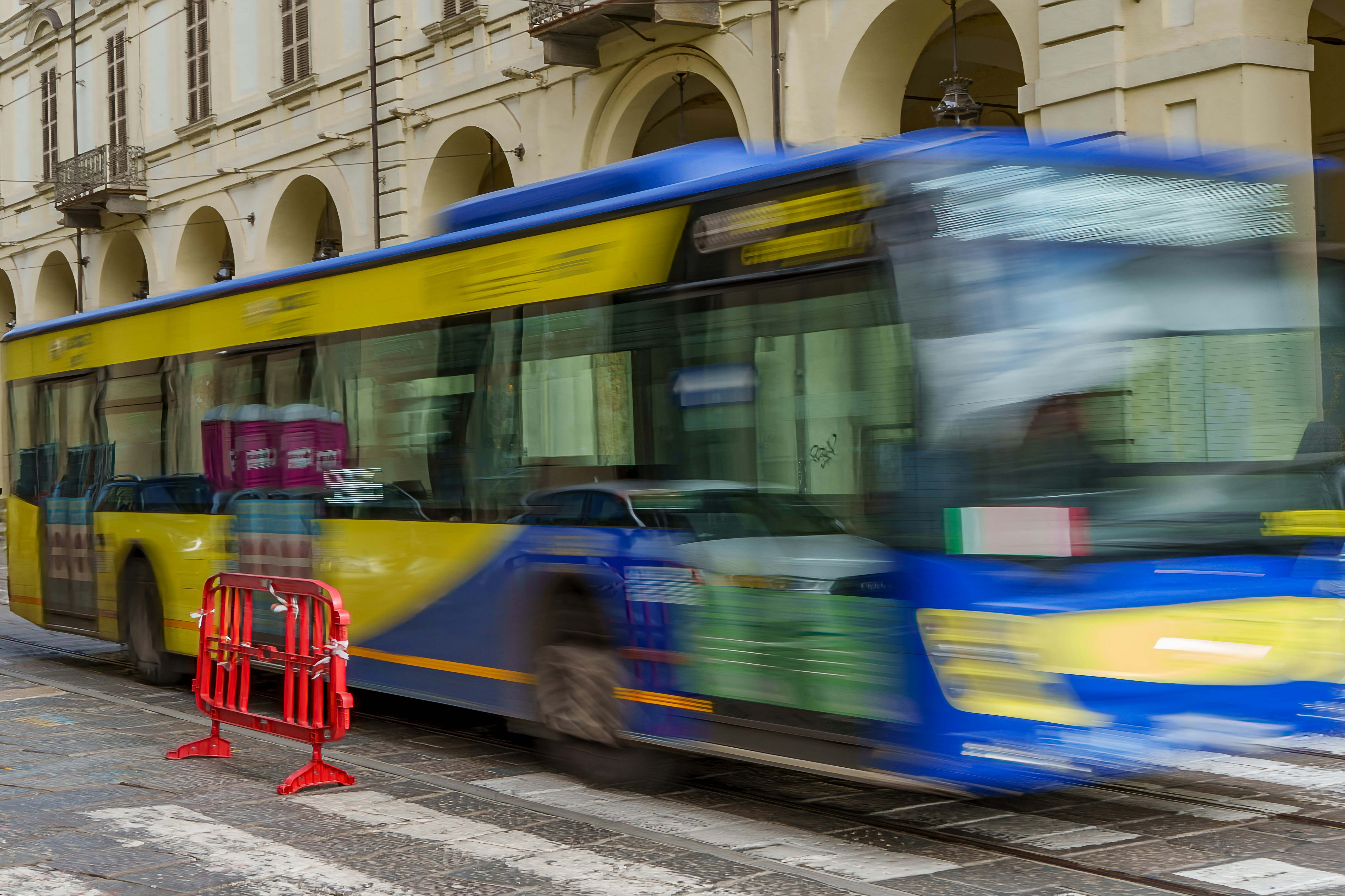 Blurring Forward: A Blue-Yellow City Bus in Motion