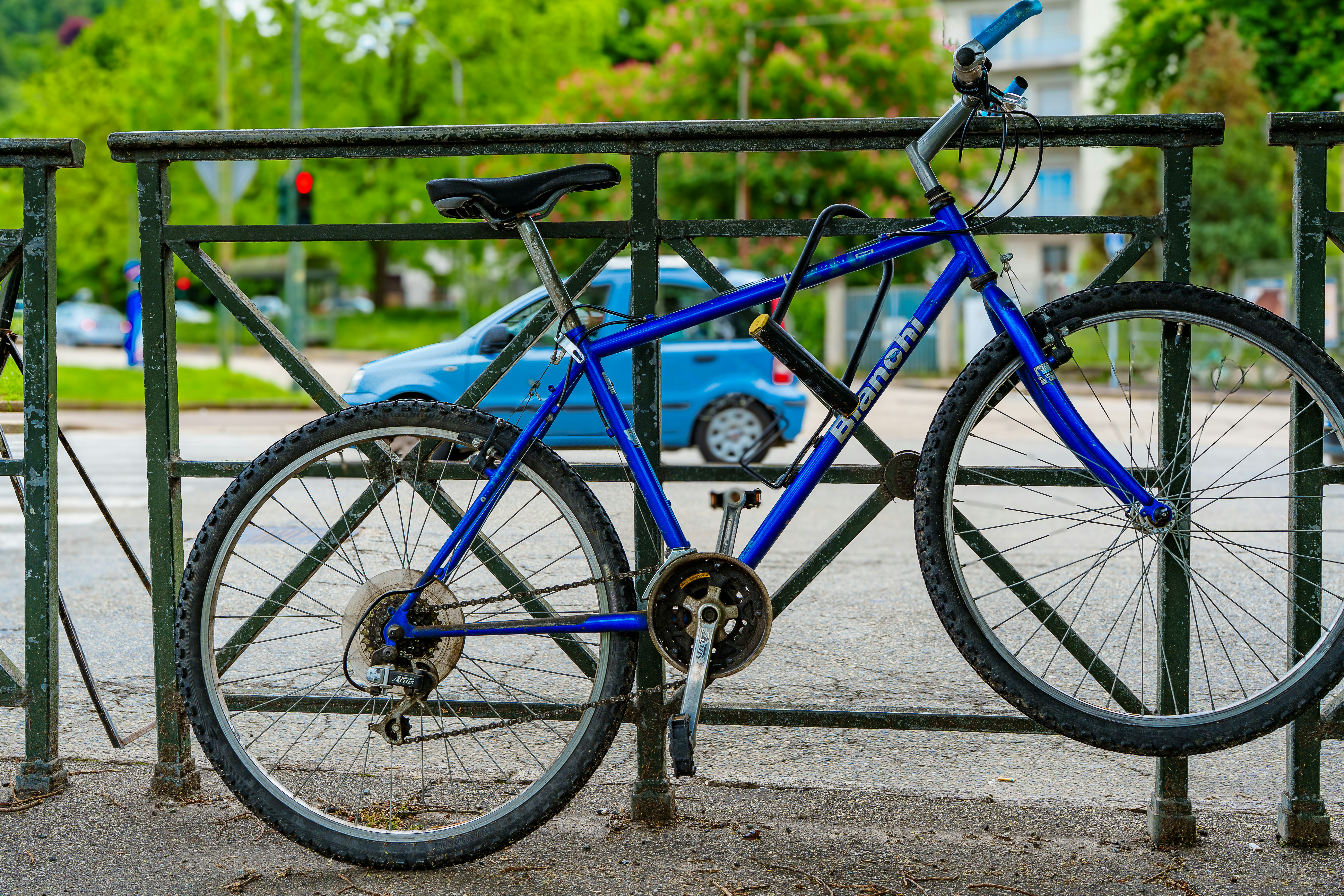 Blue Bicycle Guarded by a Rail Fence in Urban Square