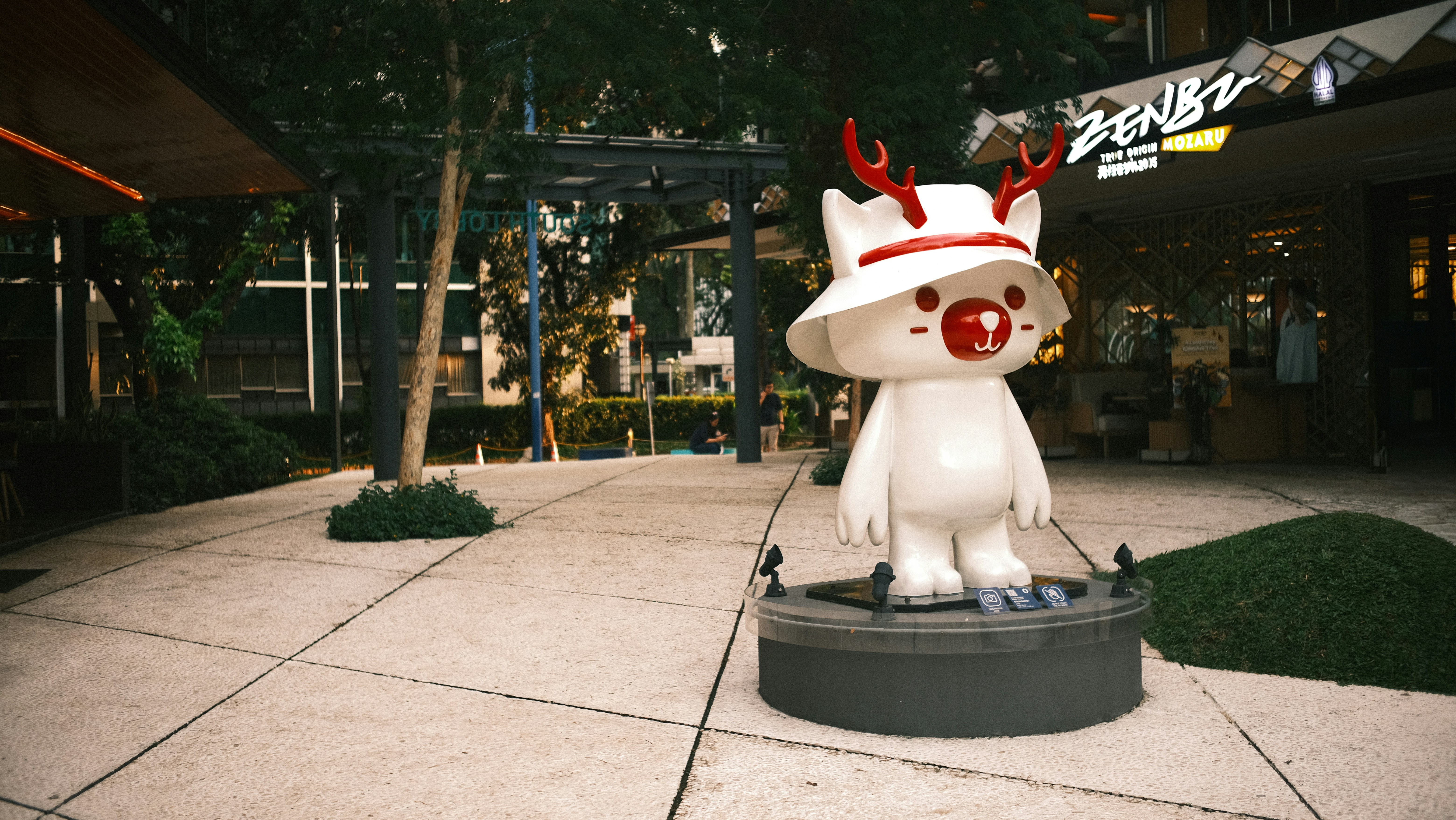 Festive statue under urban glow: a holiday mascot guards the plaza