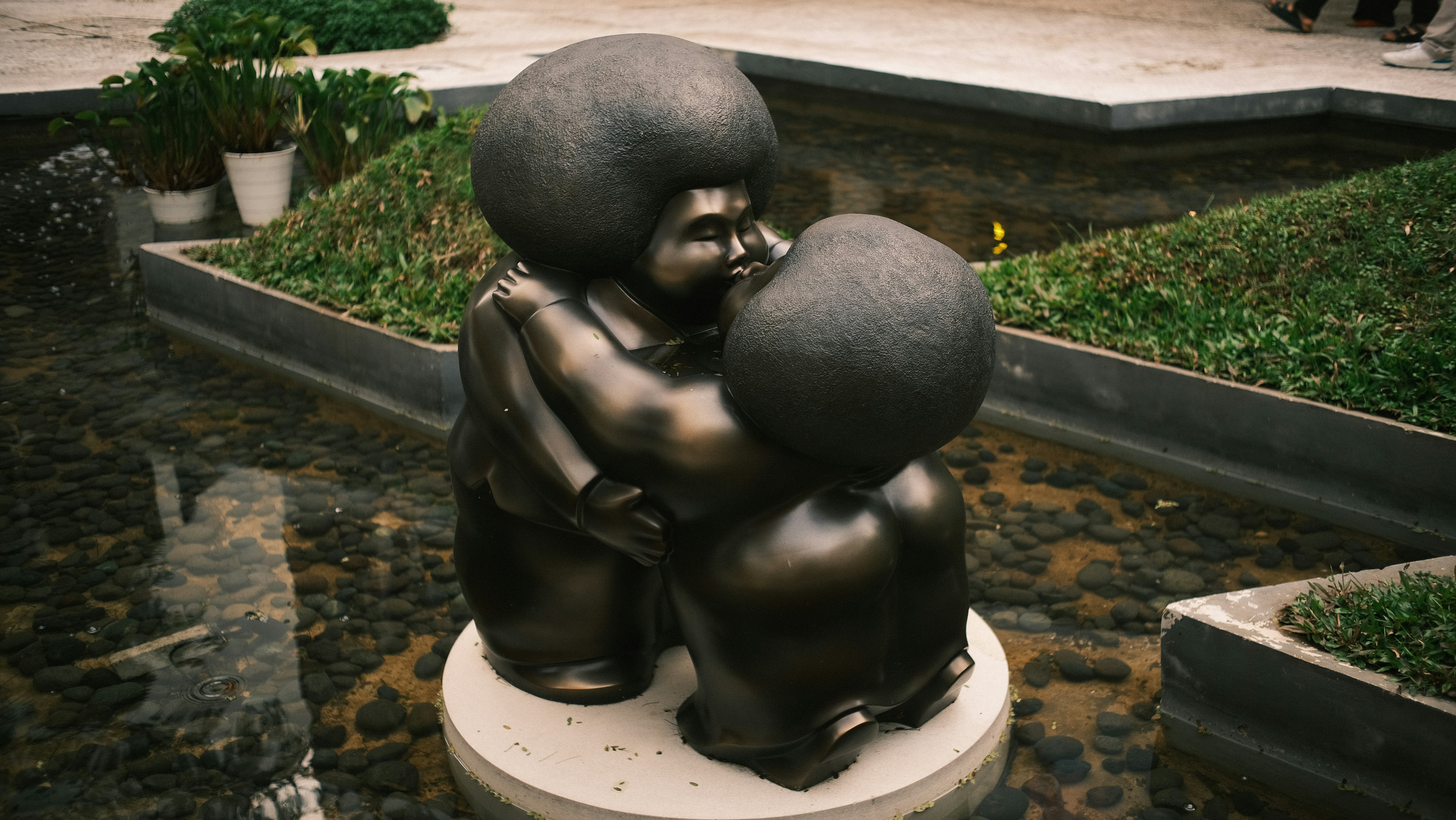 Toppling Tenderness: twin bronze figures in quiet embrace