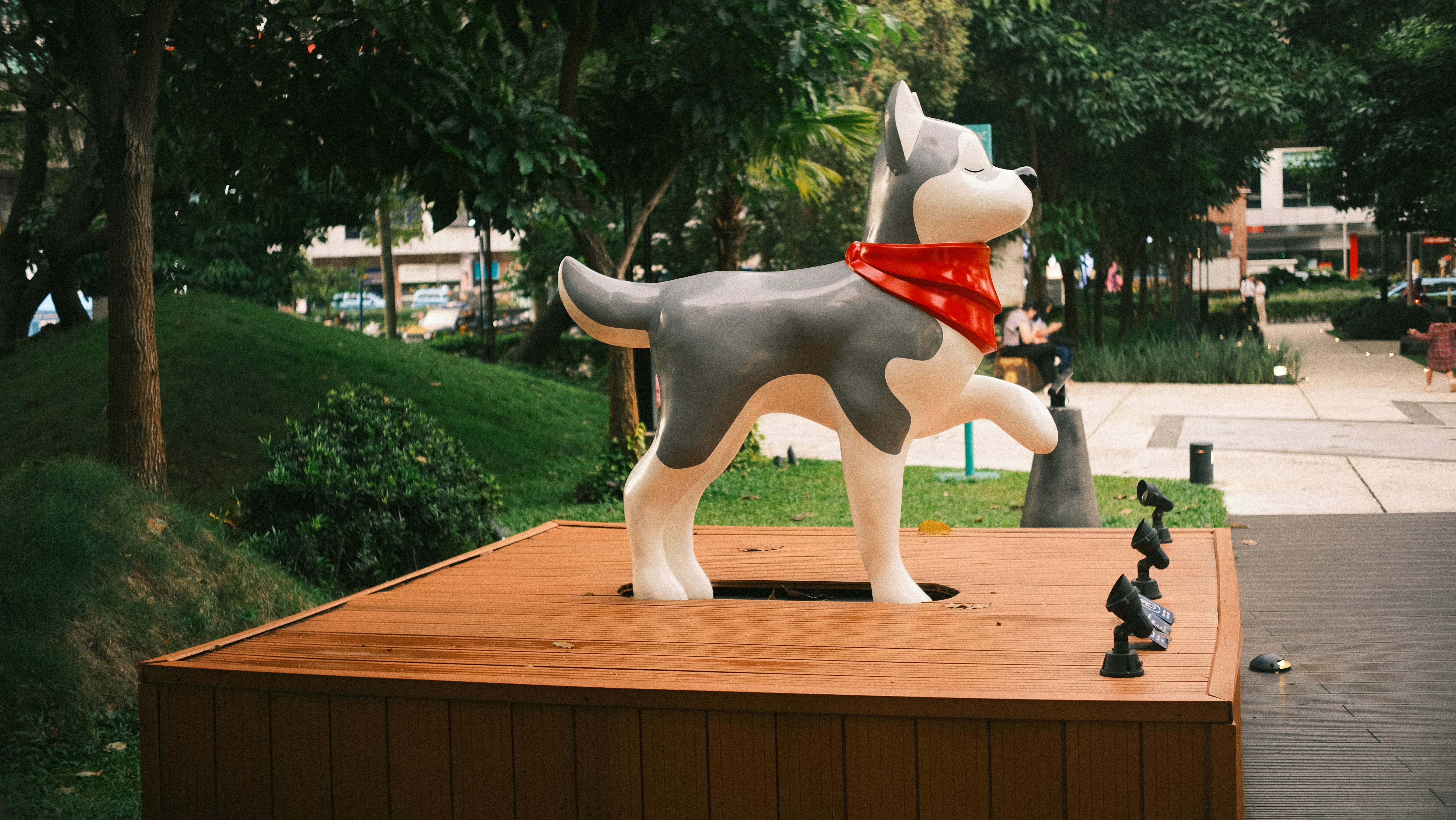 Red scarf, painted dog: a playful statue anchors a sunlit plaza