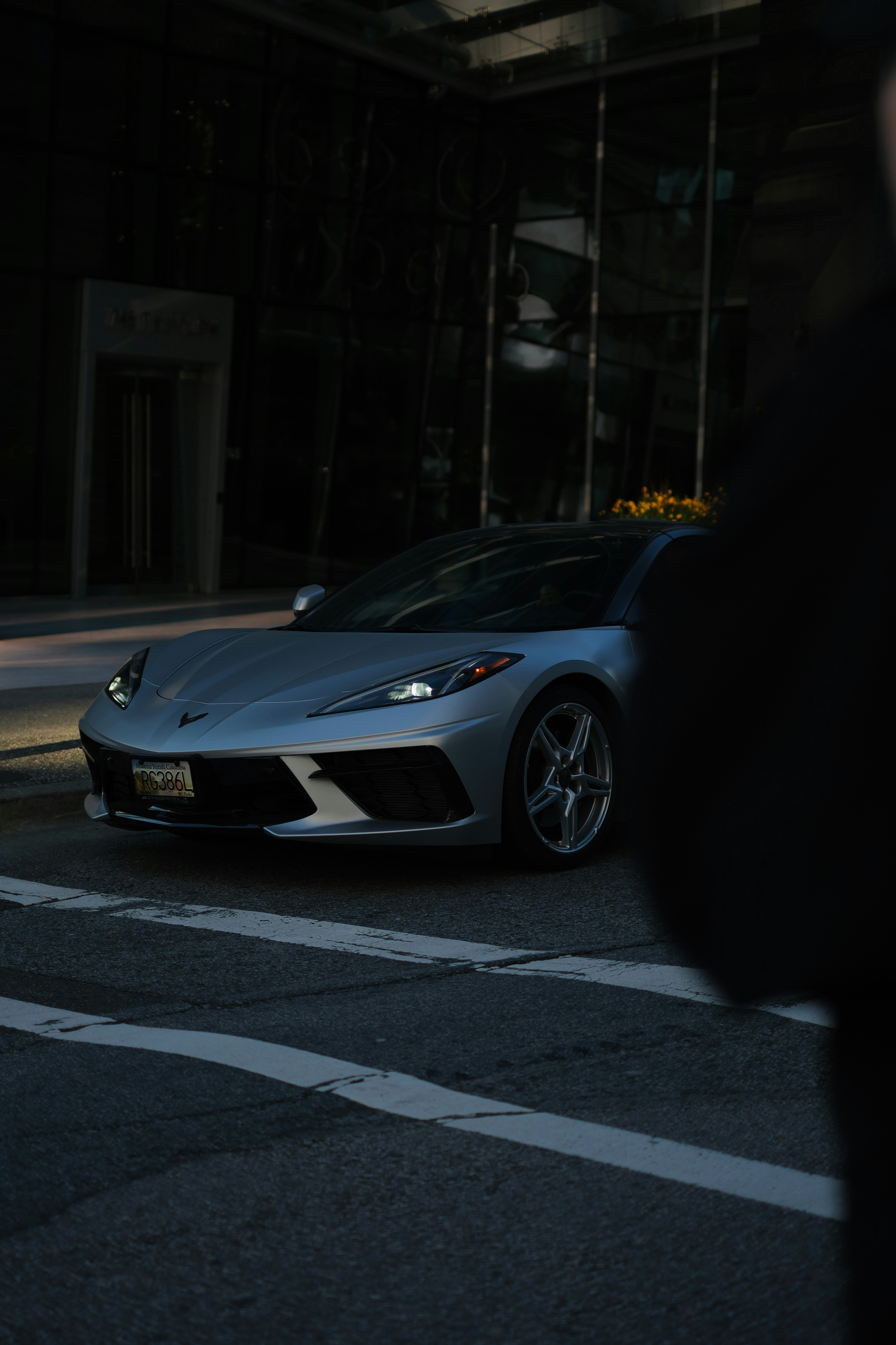 Low Sun, High Gear: A Silver Corvette Anchored in Urban Dusk