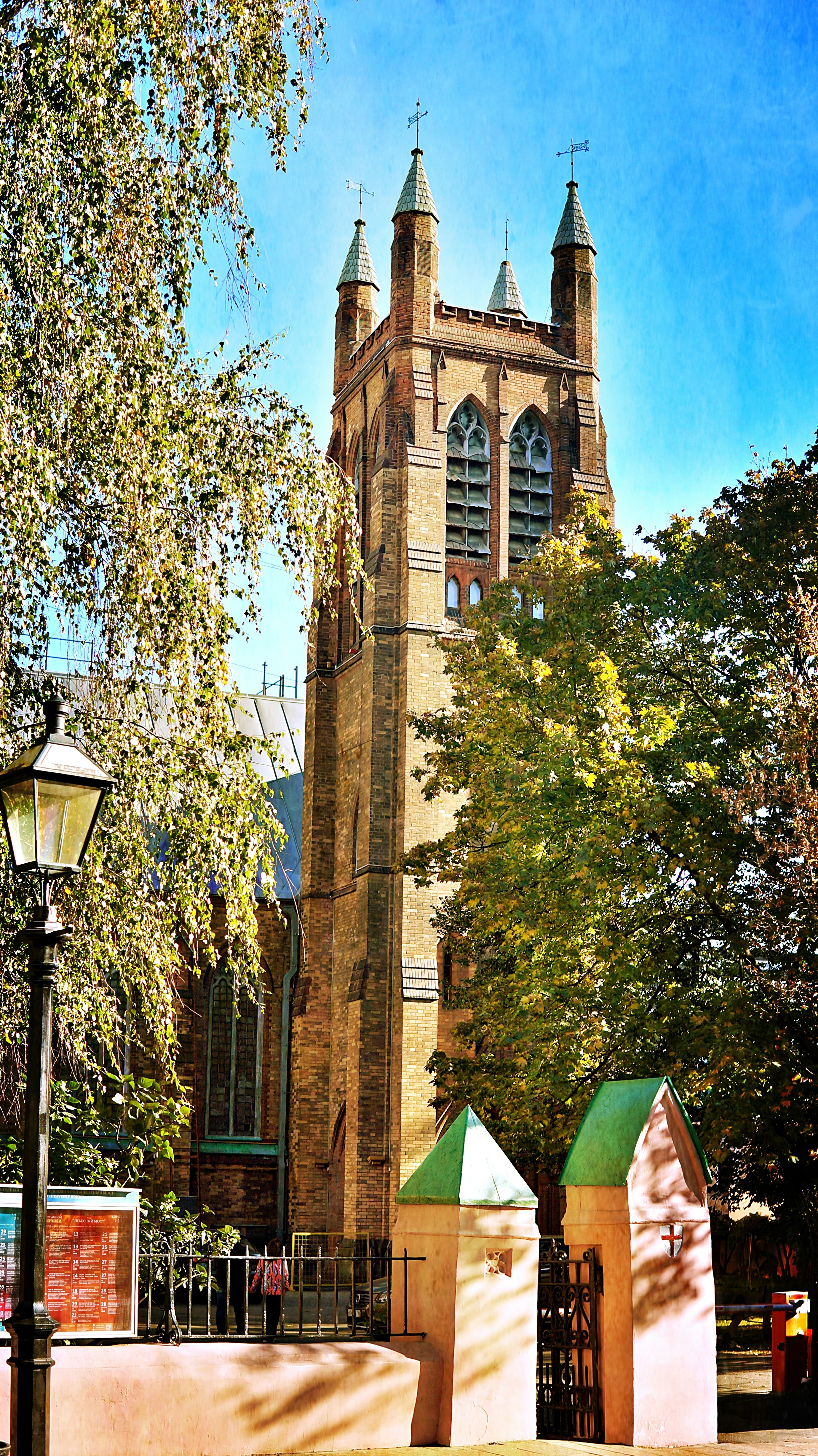 Towering Brick Bell Tower Surrounded by Autumn Trees