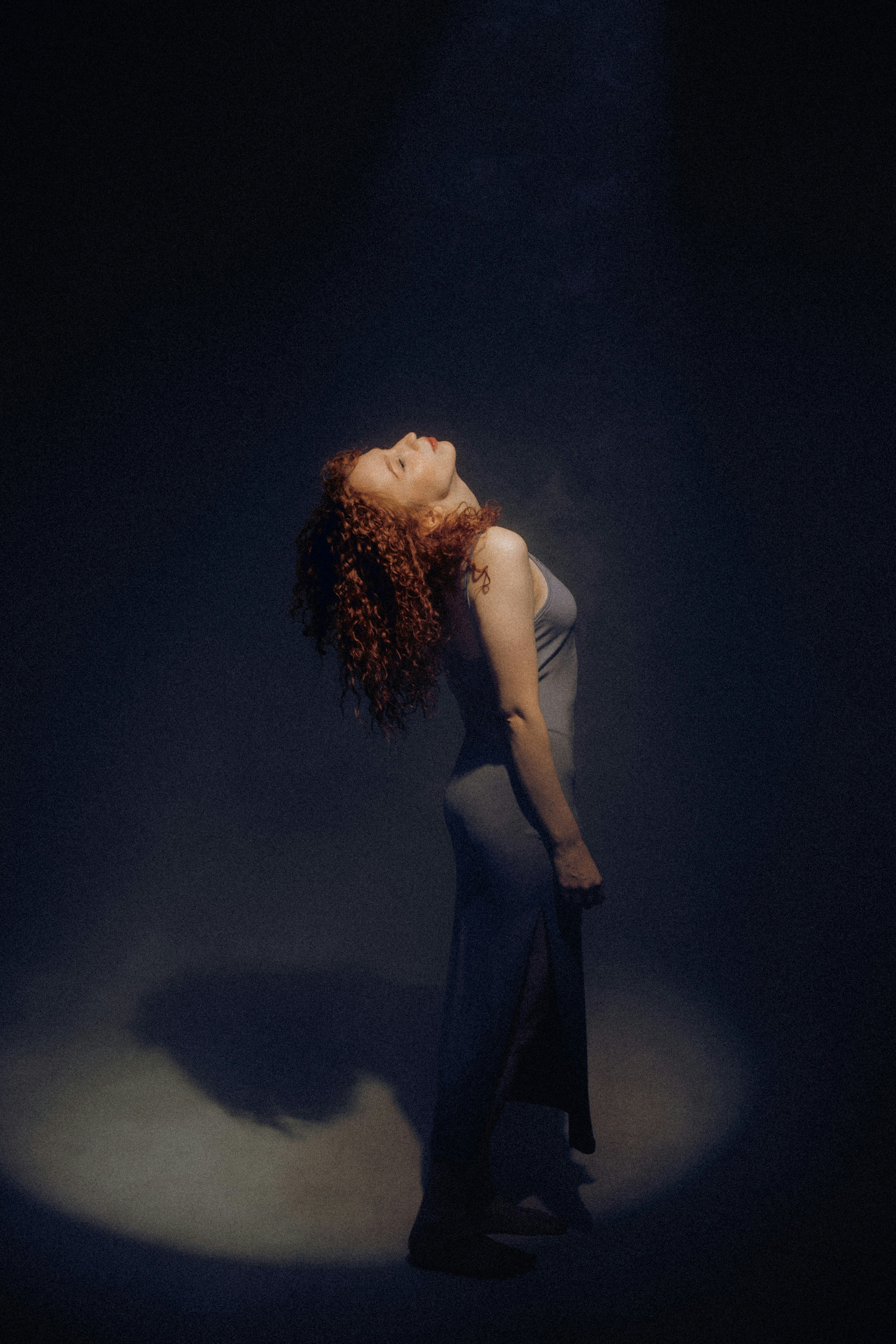 Raised Silhouette: A Quiet Moment with a Dancer in Velvet Darkness