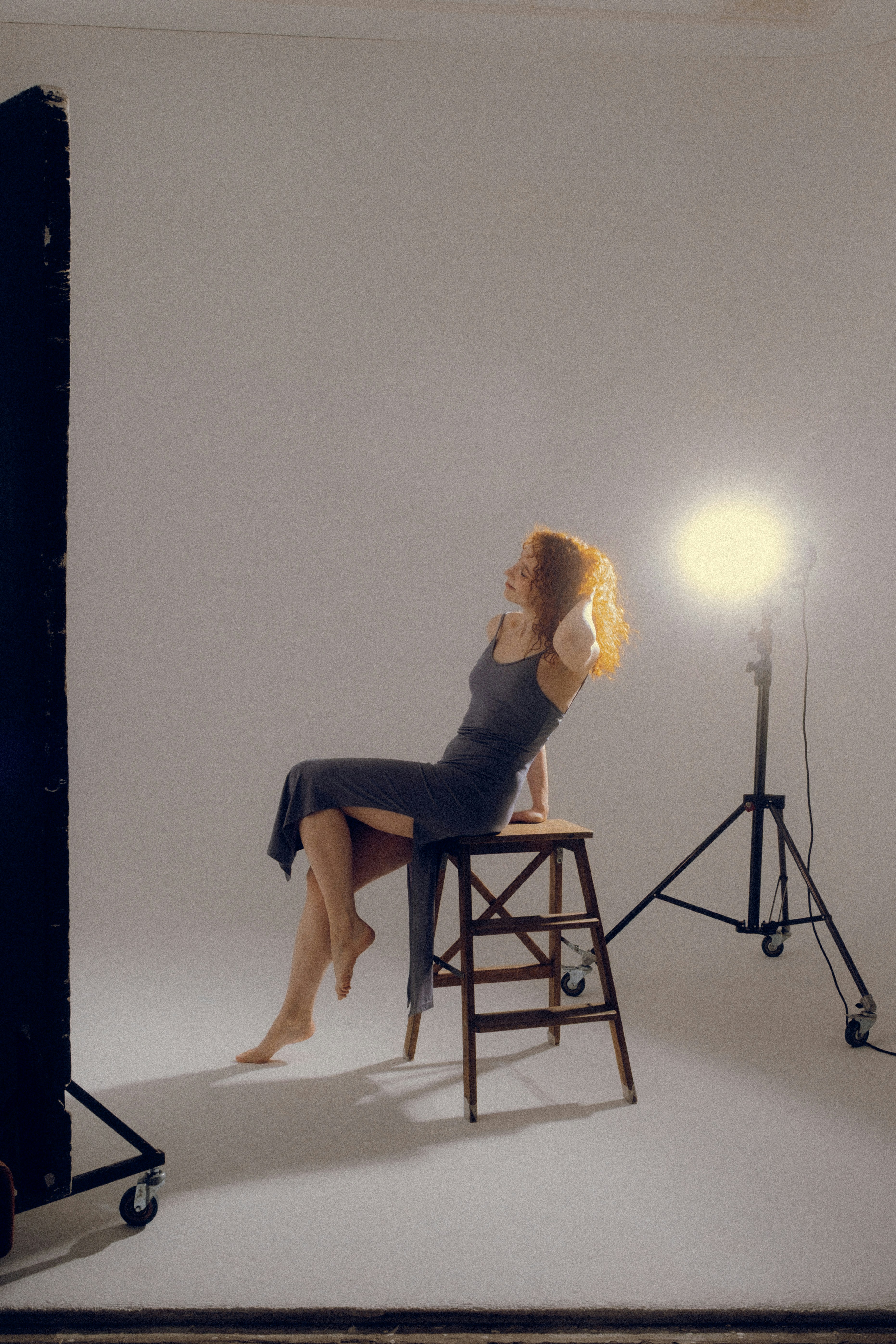 Silhouette in Spotlight: A Quiet Pose on a Studio Stool