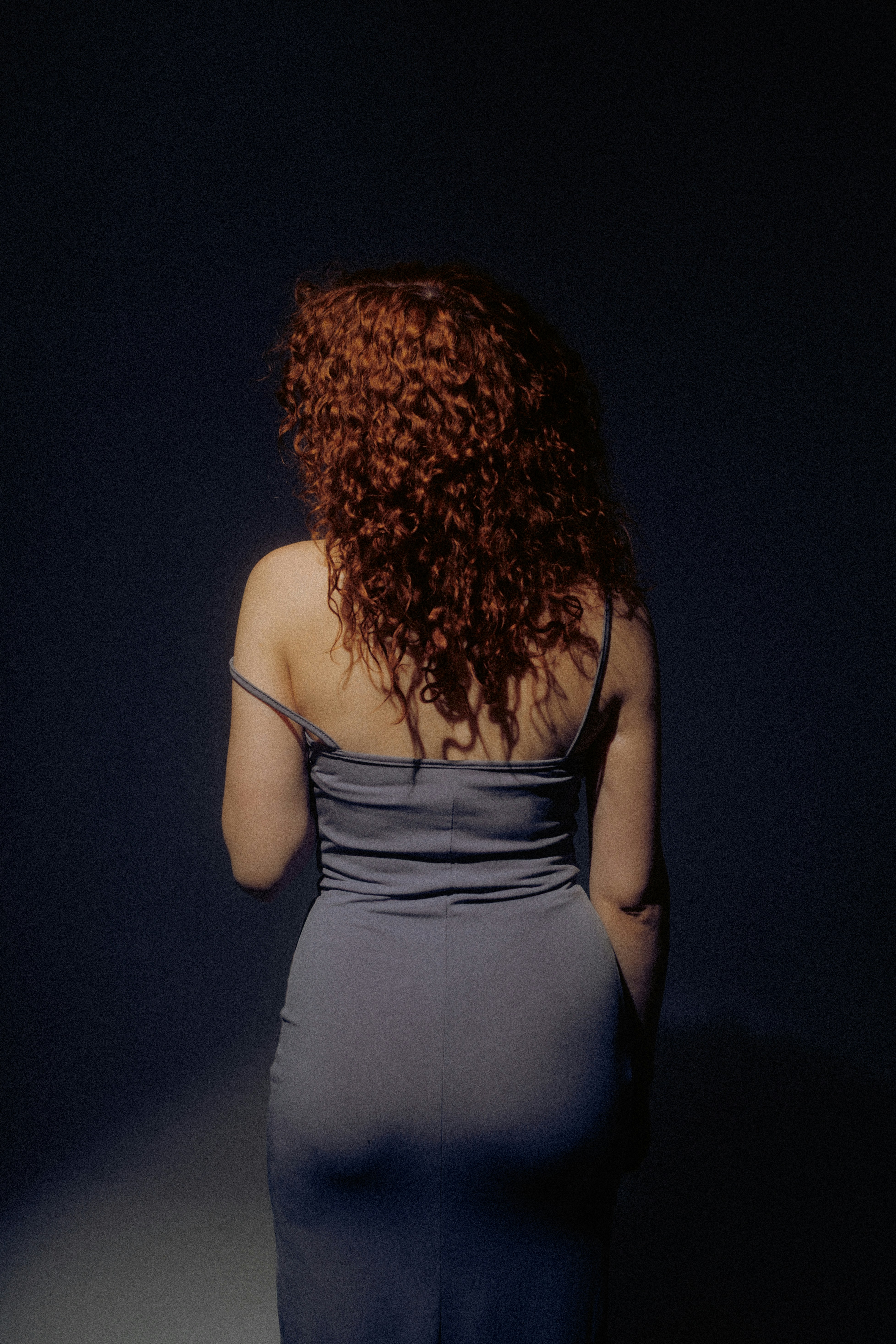 Backlit Quiet: Portrait of a Red-Haired Figure in Midnight Silhouette