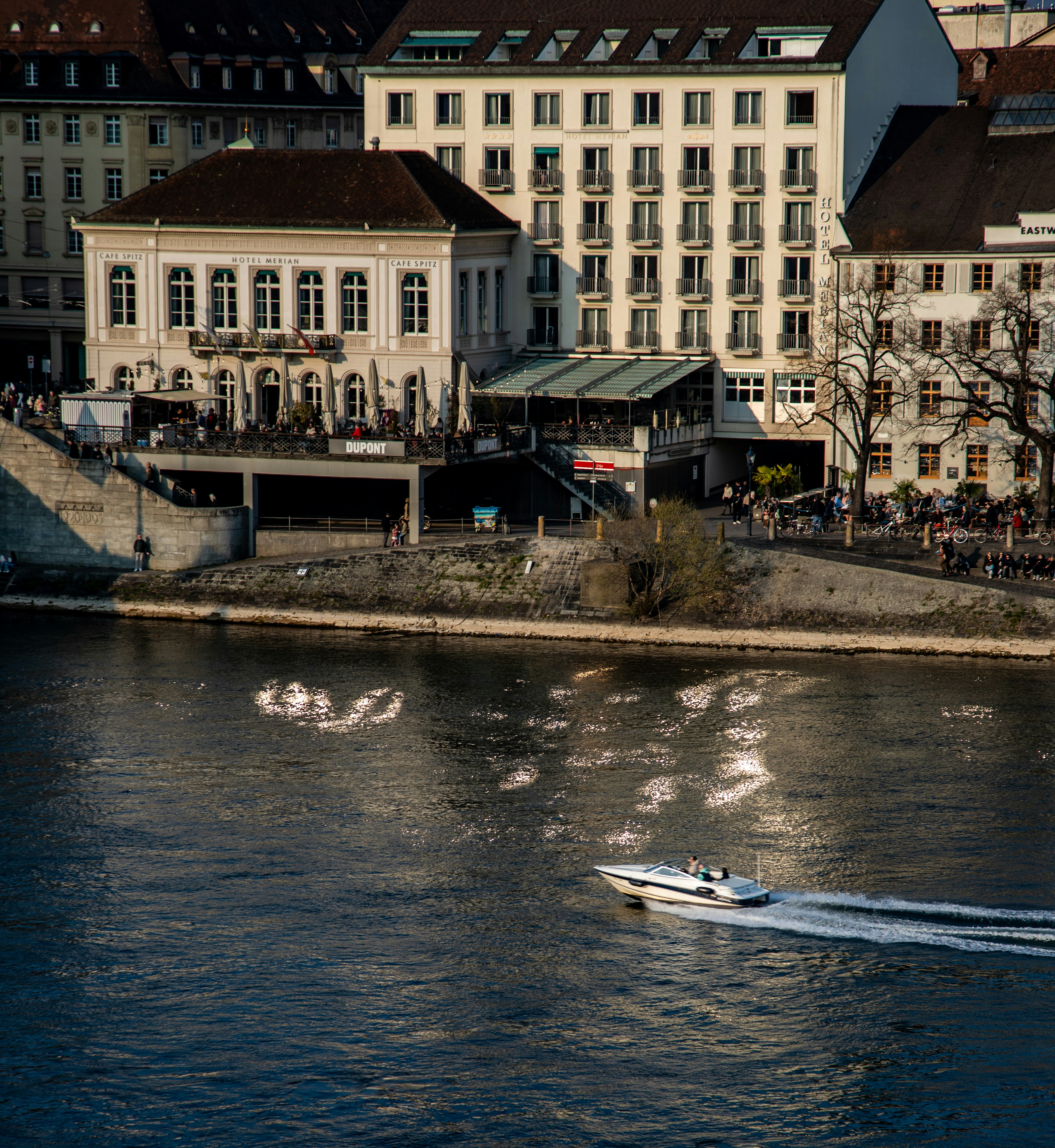 Riverside Terrace: A Boat Glides Past Historic Waterfront Facades