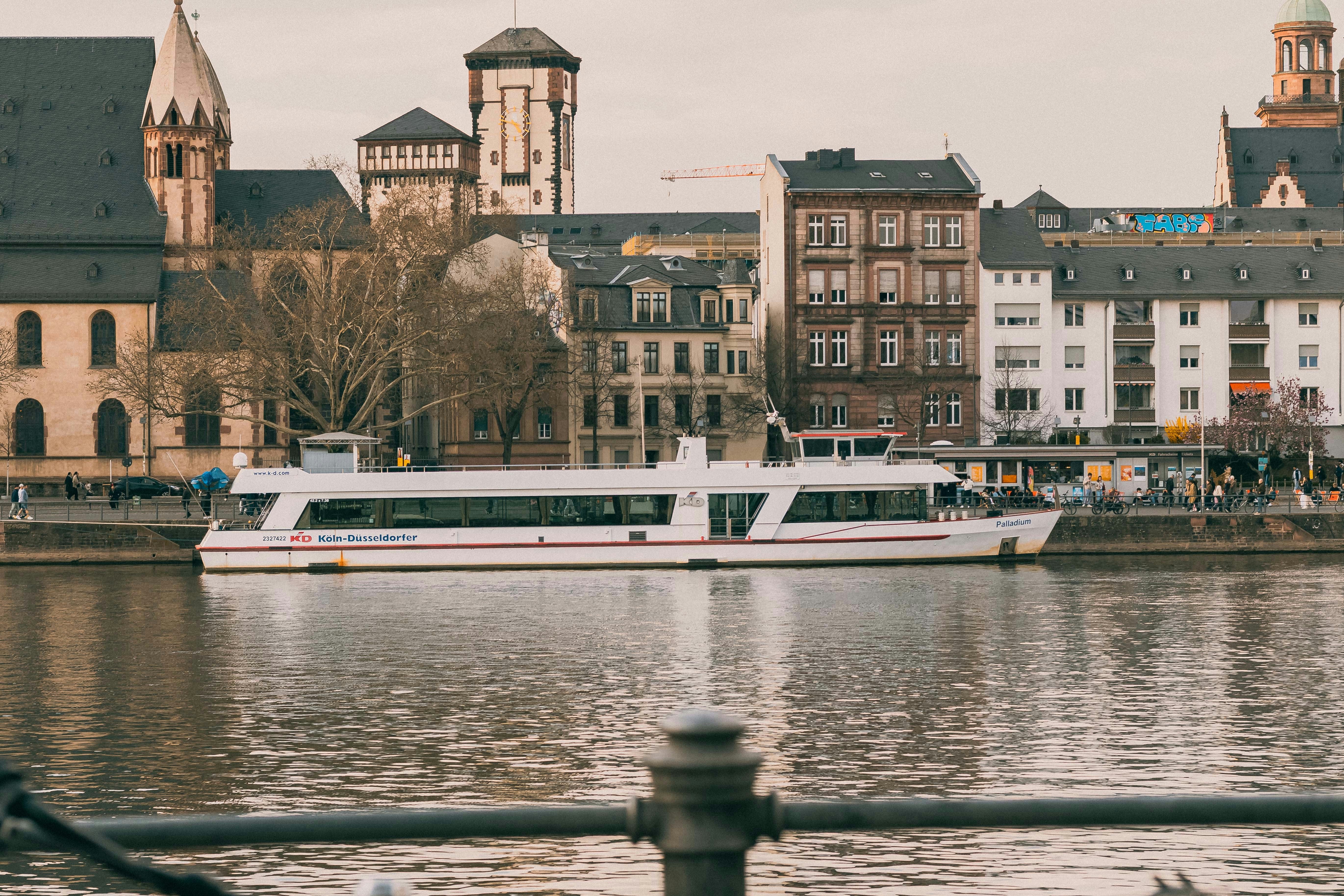 City Vessel at Riverside: A Quiet Riverfront Scene with a Modern Tour Boat