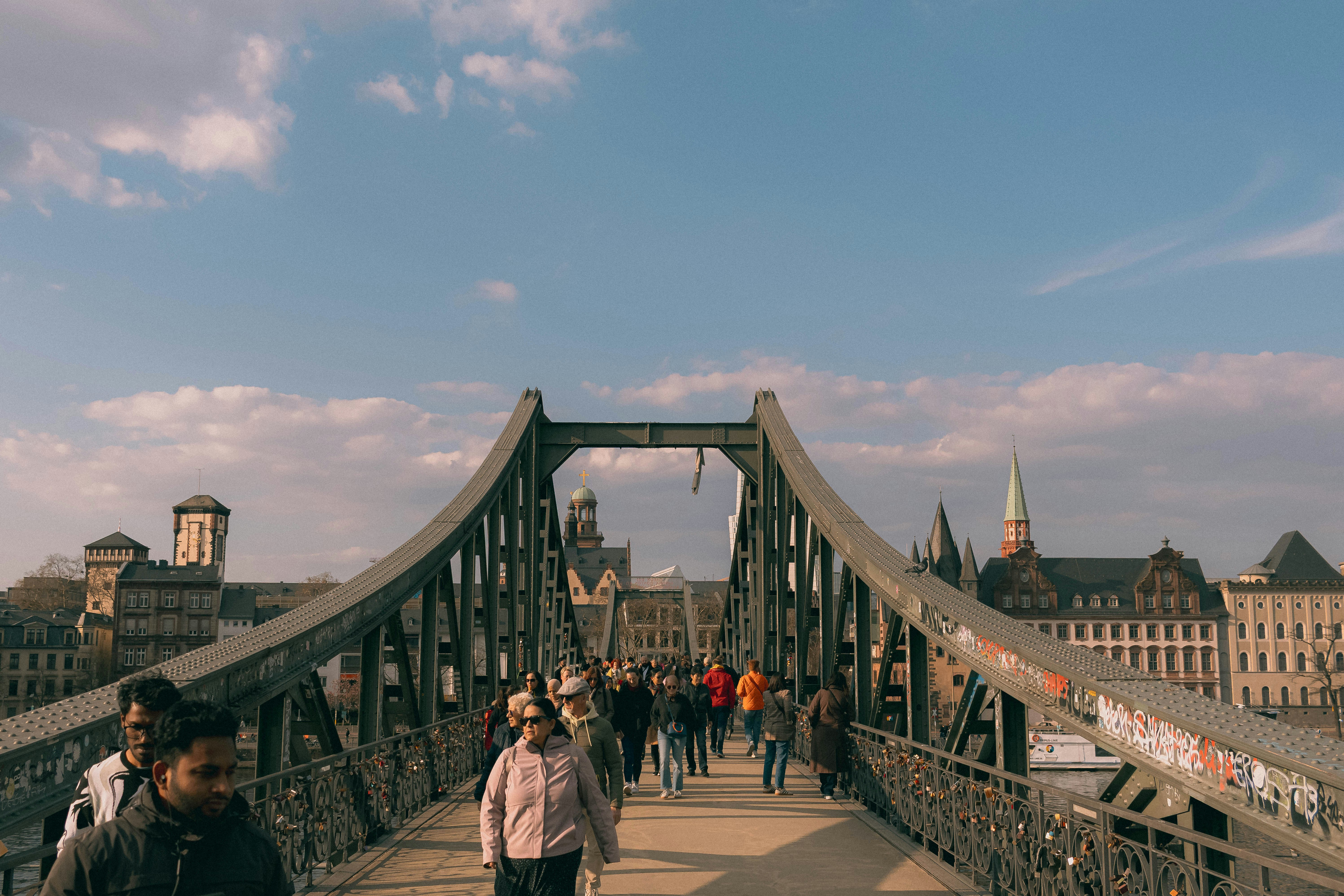 People Trek the Iconic Pedestrian Bridge into a Historic Cityscape