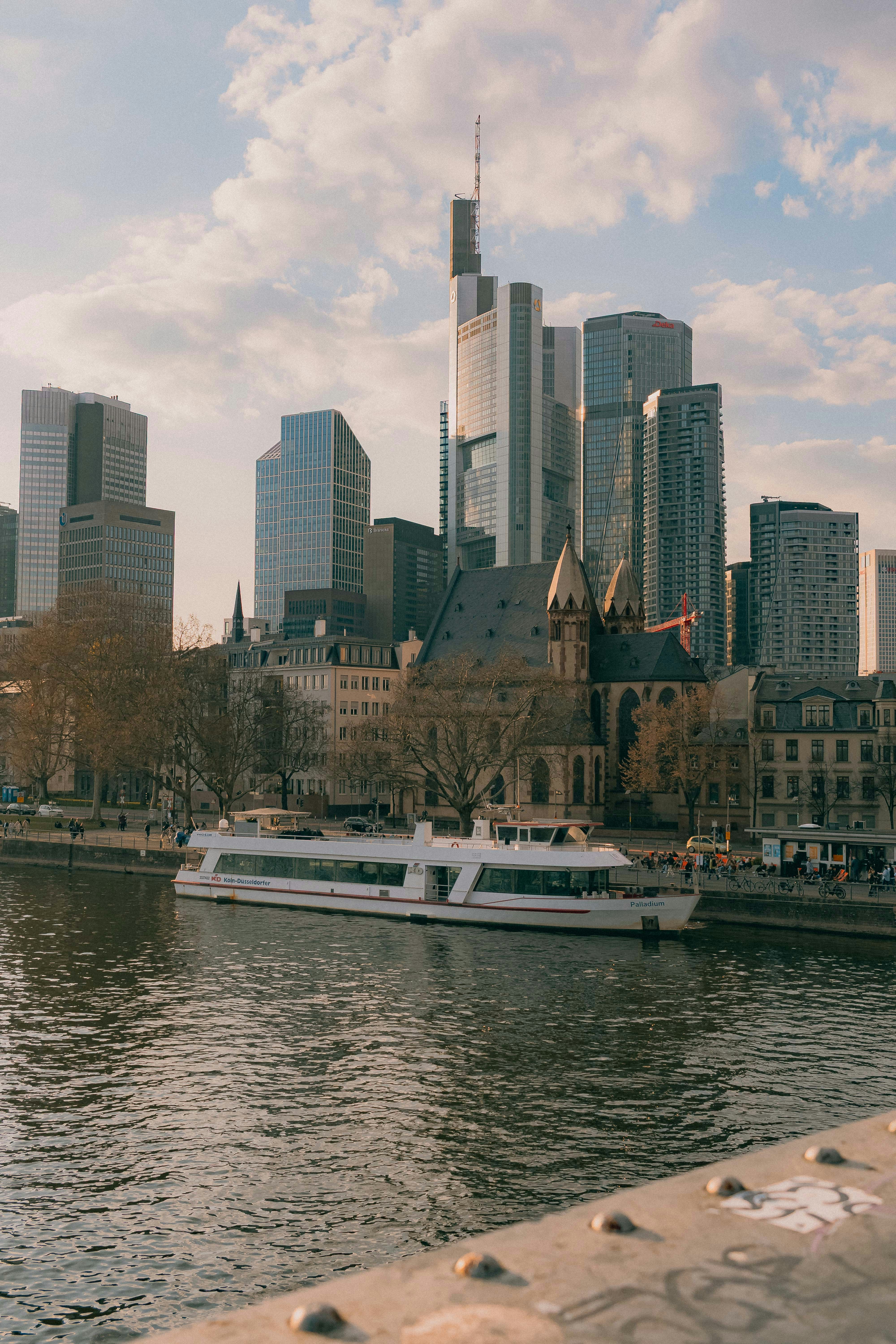Riverfront Cathedral and Glass Skyscrapers Behind a Floating Tour Boat